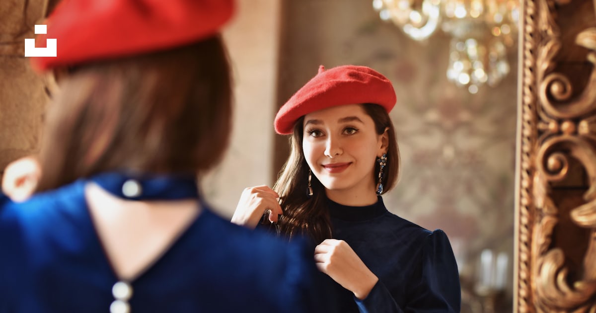 빨간 모자를 쓴 여자가 거울에 비친 자신을 보고 있다 사진 Unsplash의 무료 빈티지 스타일 이미지