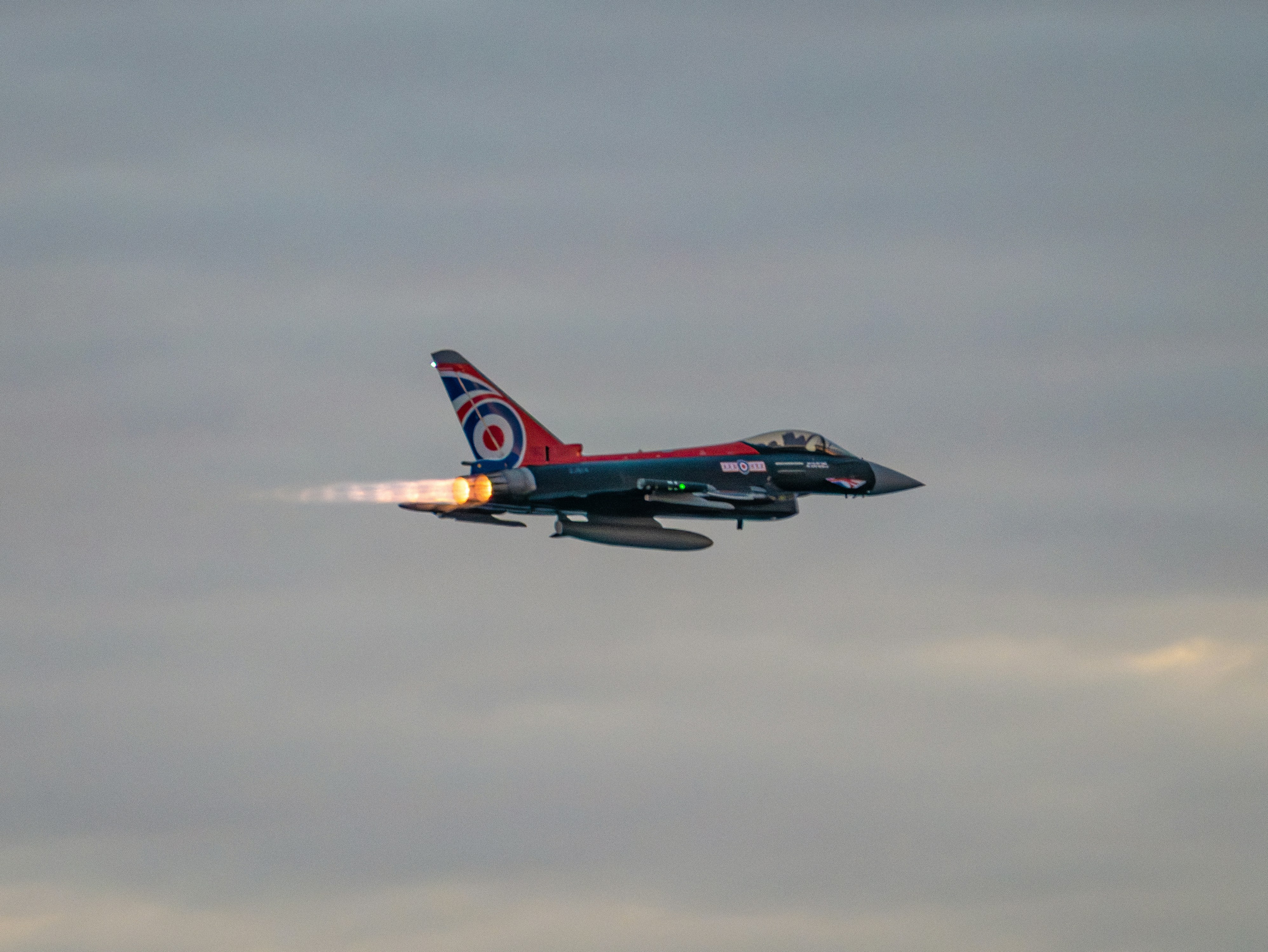 Afterburner Arrow: A Red-White-Blue Livery Slices Through a Clouded Sky