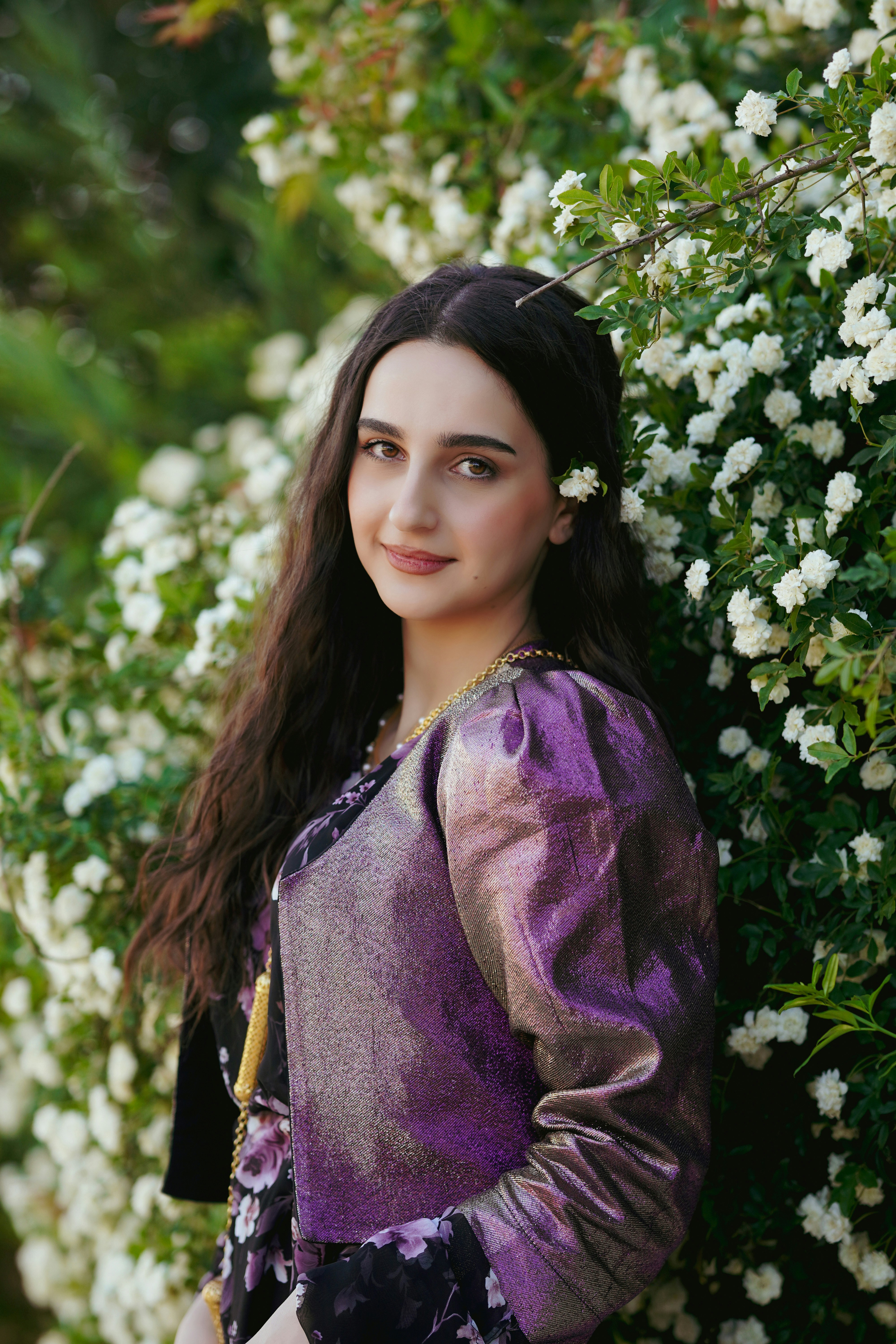 A woman standing next to a bush with white flowers photo – Free Face ...