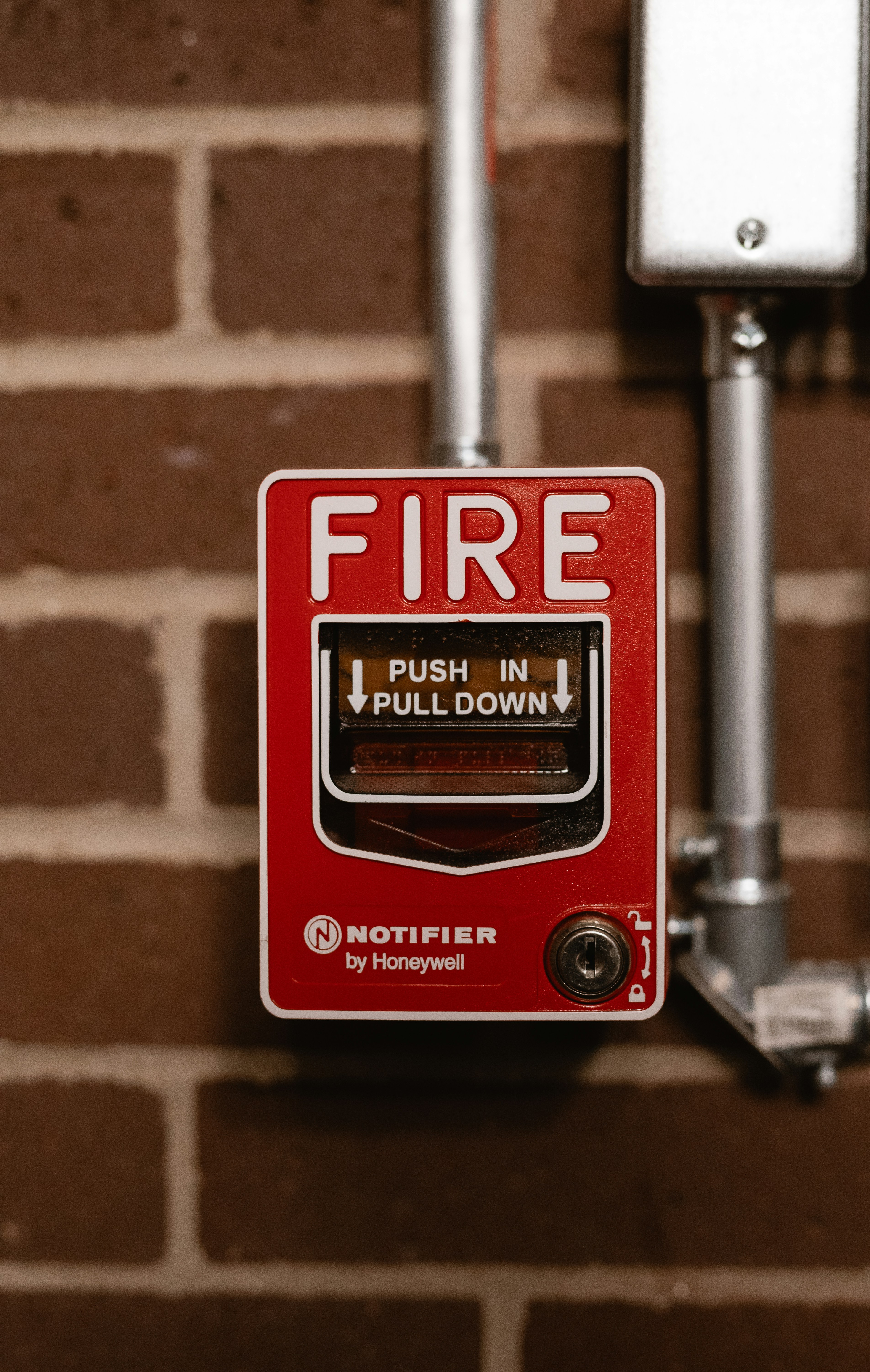 A red fire button on a brick wall photo – Free Street photography Image ...