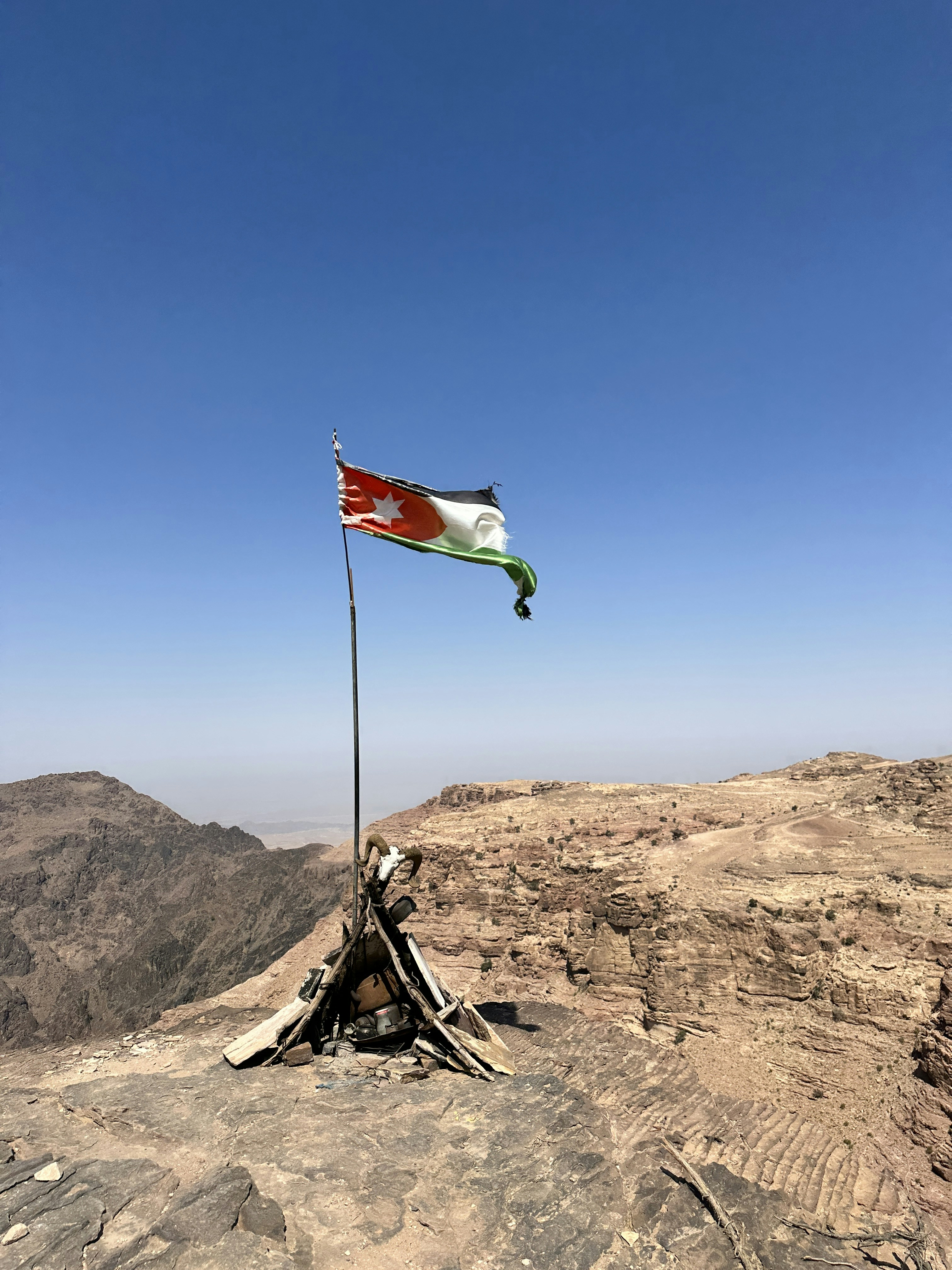 Windward Emblem: A Jordan Flag Clings to a Desert Cliff
