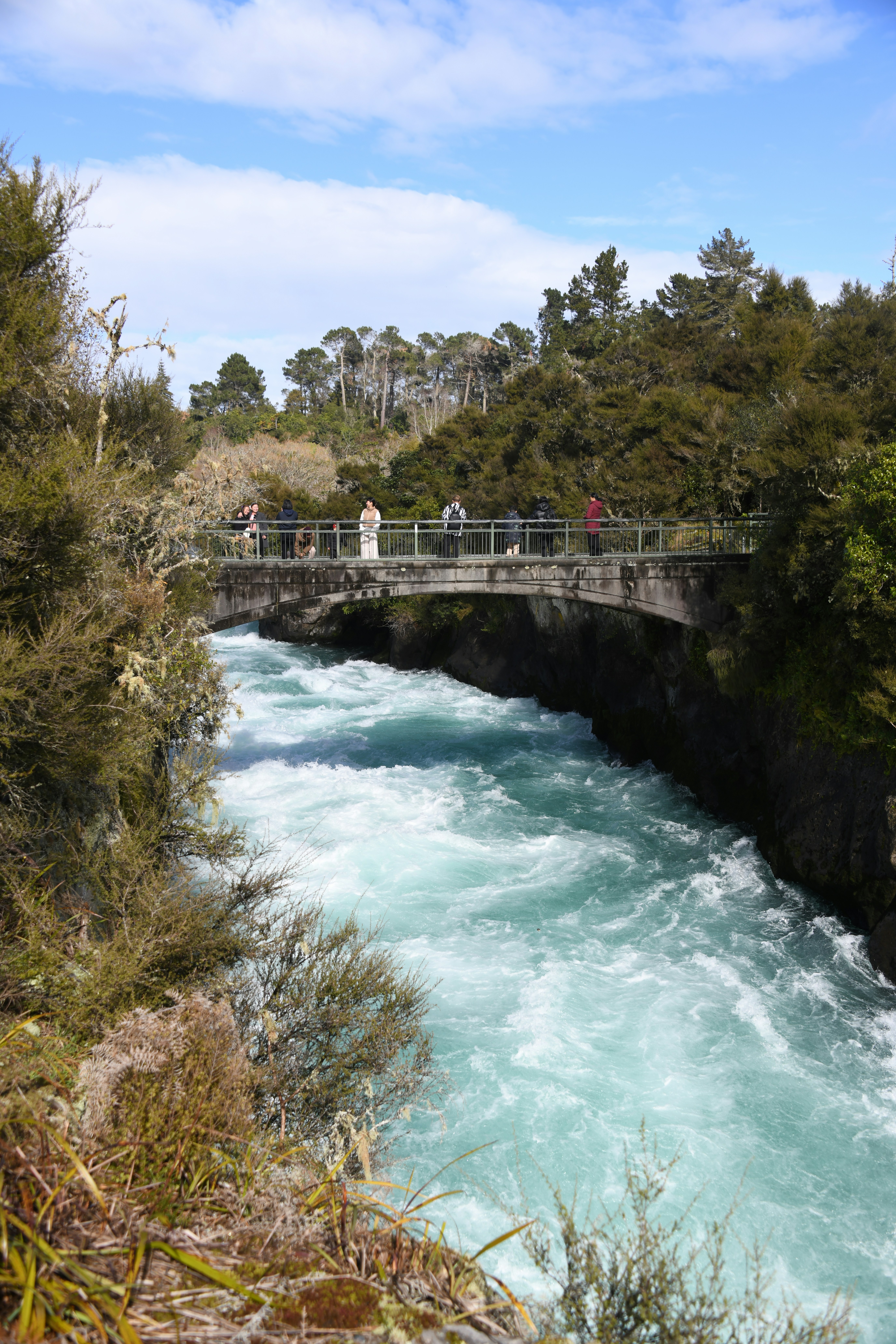 People are walking over a bridge over a river photo – Free Huka falls ...