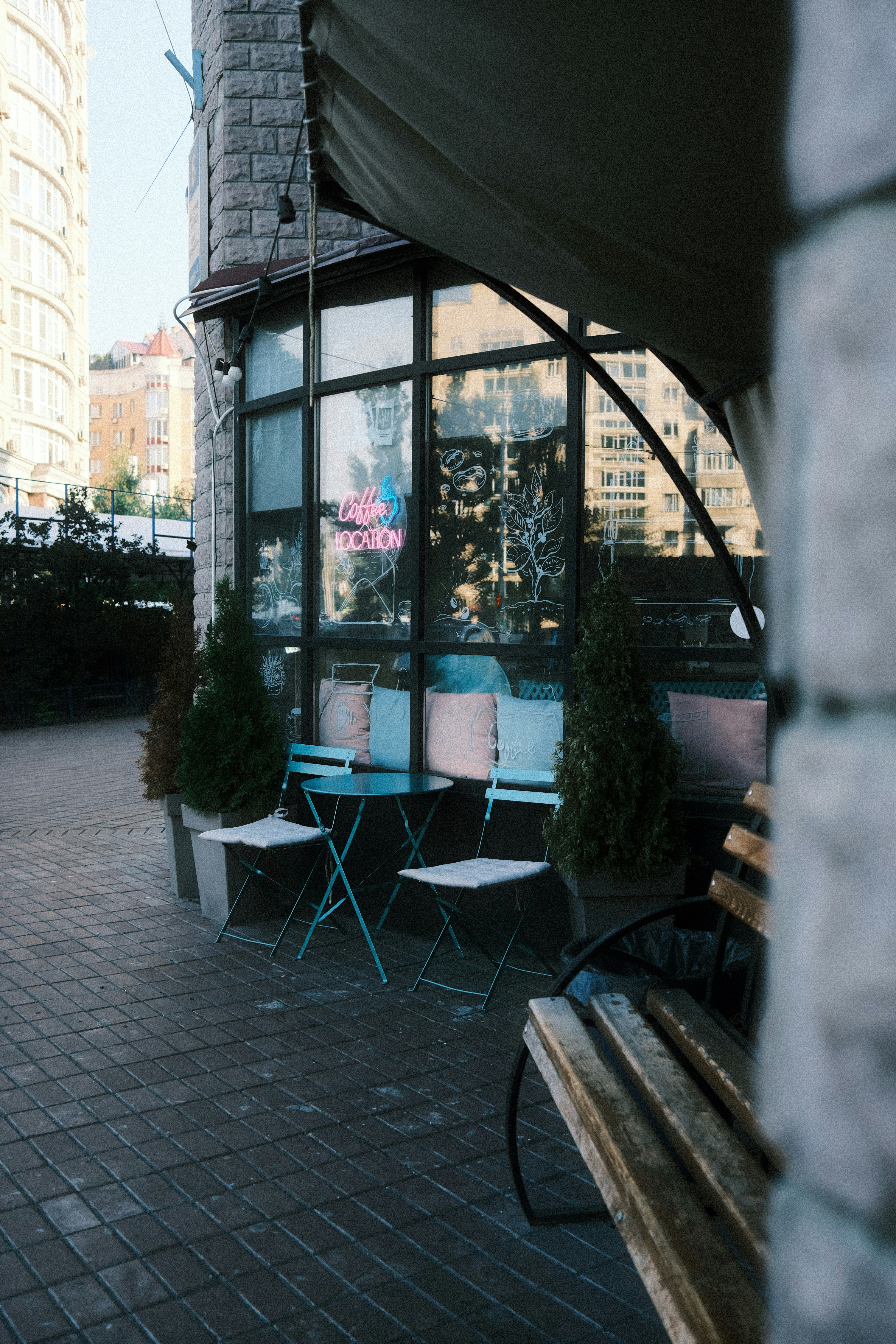 Neon Pink Sign Reflected in a Quiet City Café Facade