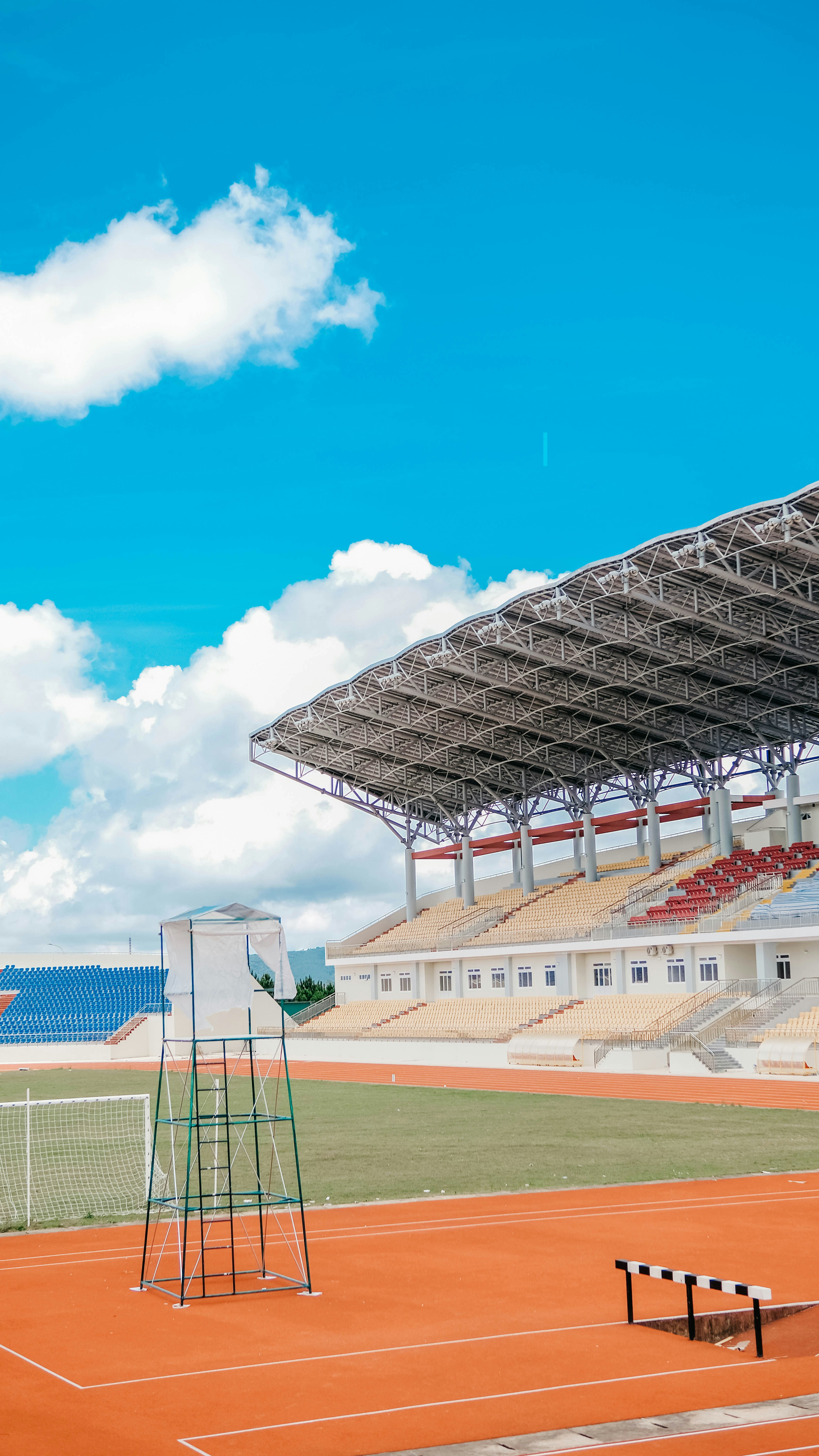 Bright Stadium Vista: Sunny Trackside Under a Sprawling Metal Roof