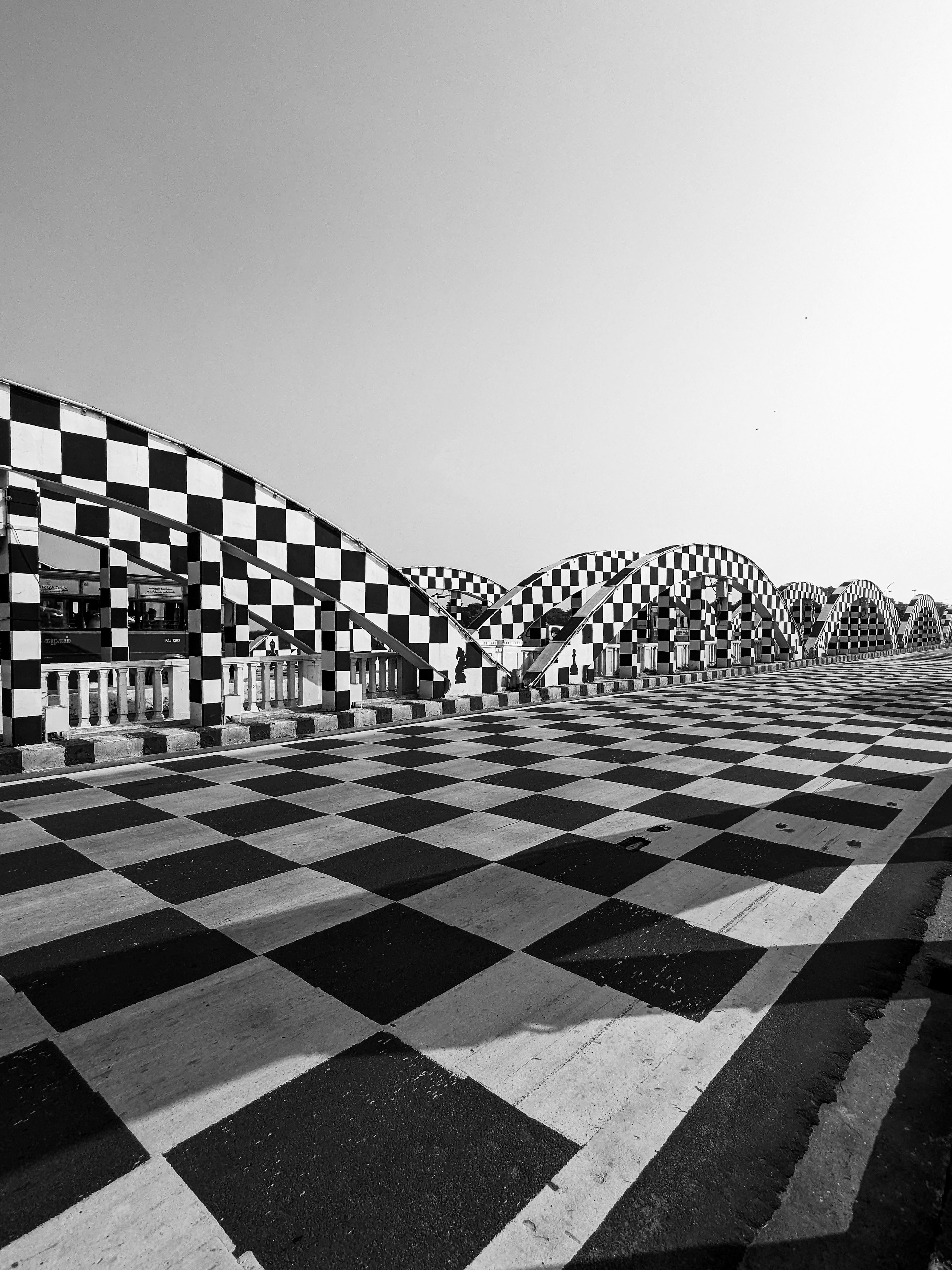 A striking black and white architectural design featuring undulating arches and a patterned pavement, creating a dynamic visual rhythm.