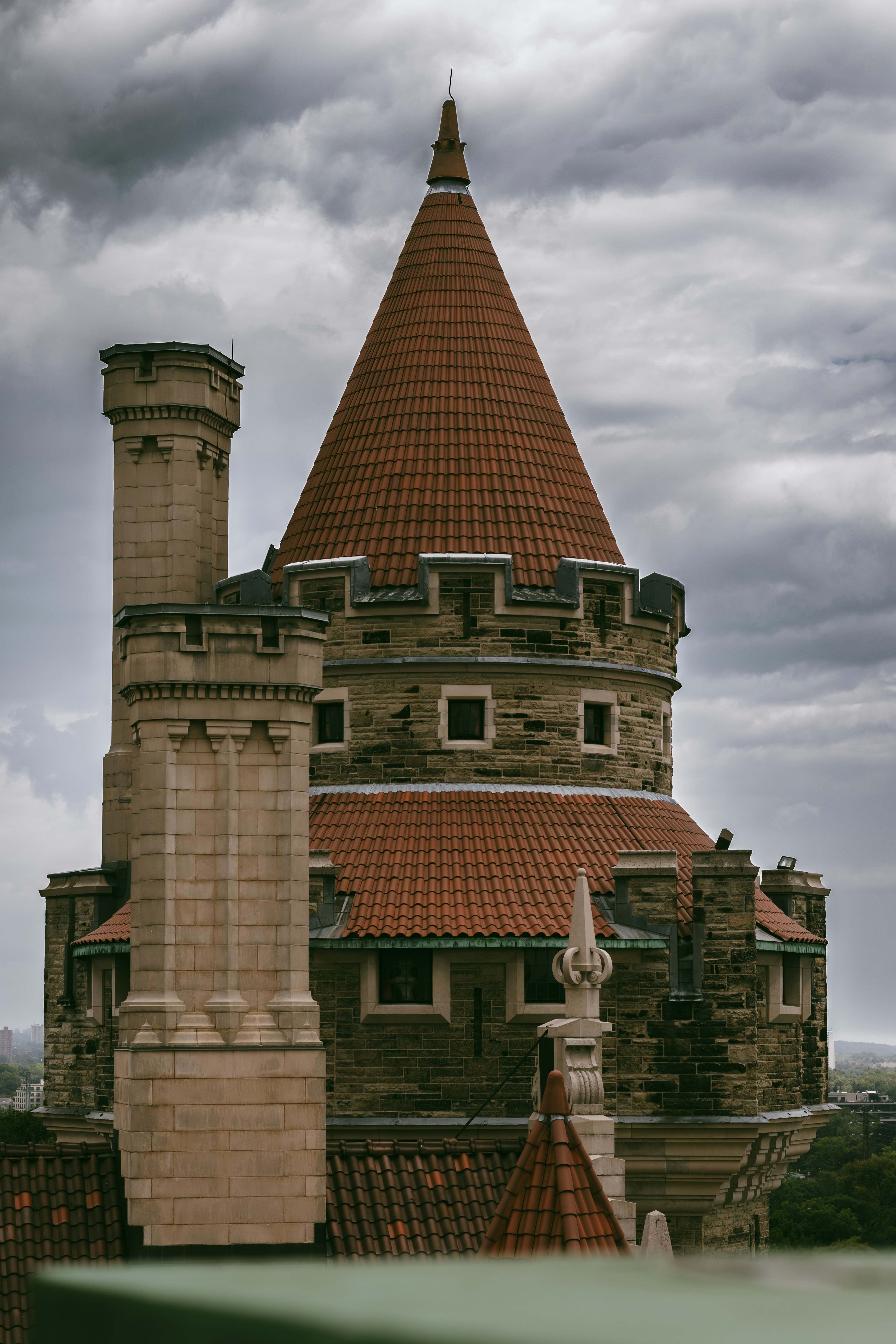 Conical Tile-roof Turret Rising Over a Stone Castle Under Clouded Skies