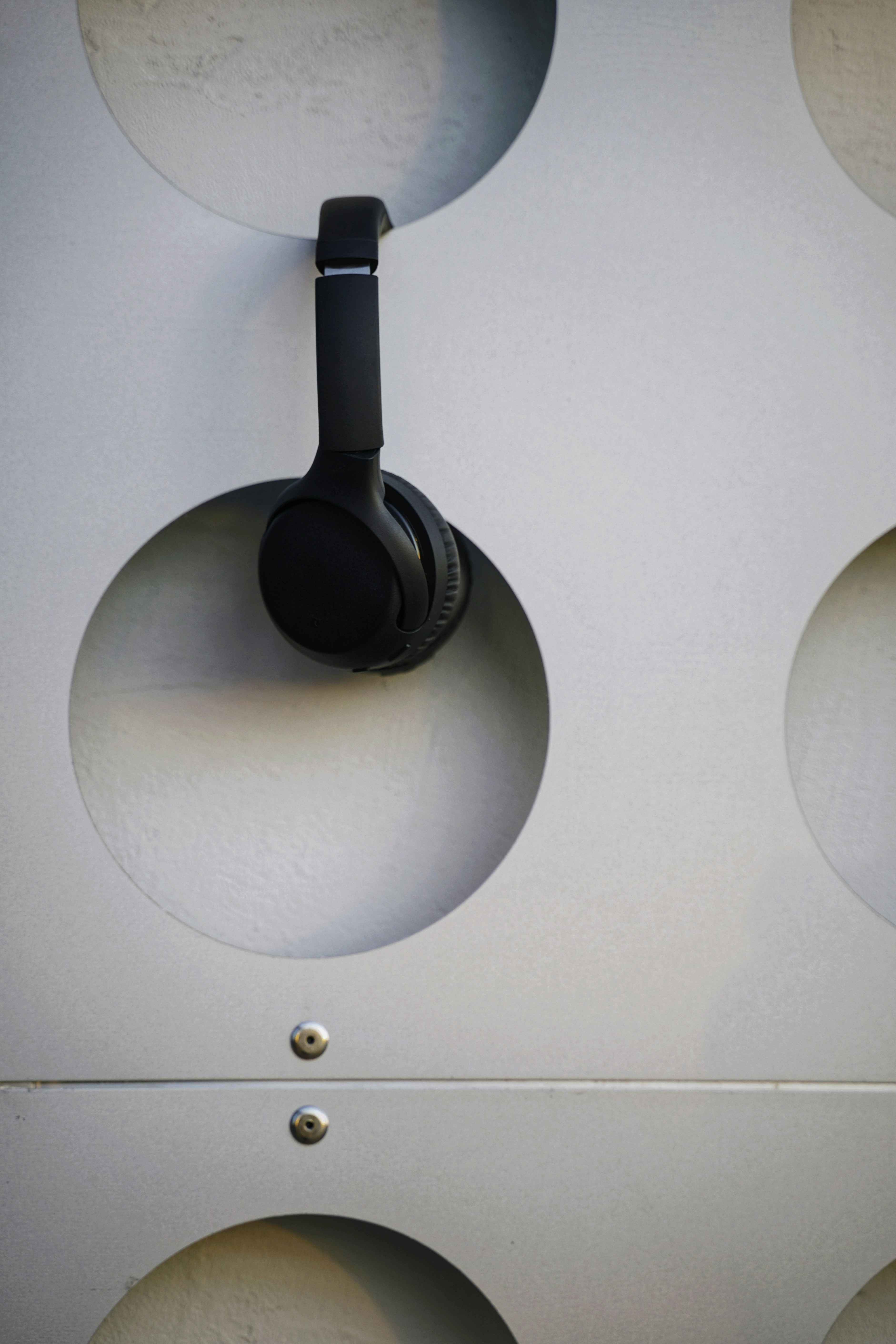 Single Black Headphones Adrift on Circular White Panels