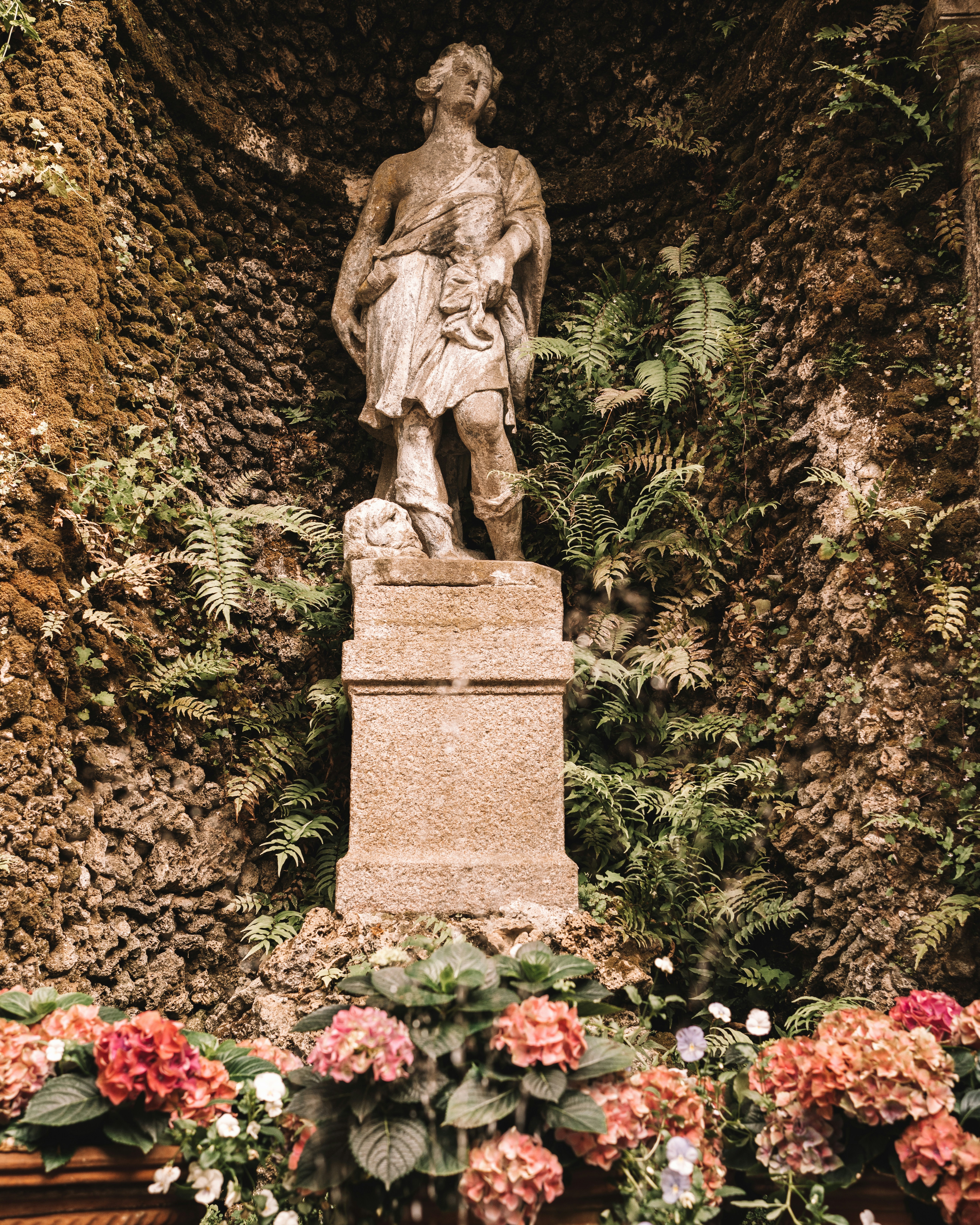 Stone Sentinel in a Fern-Wrapped Grotto Framed by Hydrangea Blush