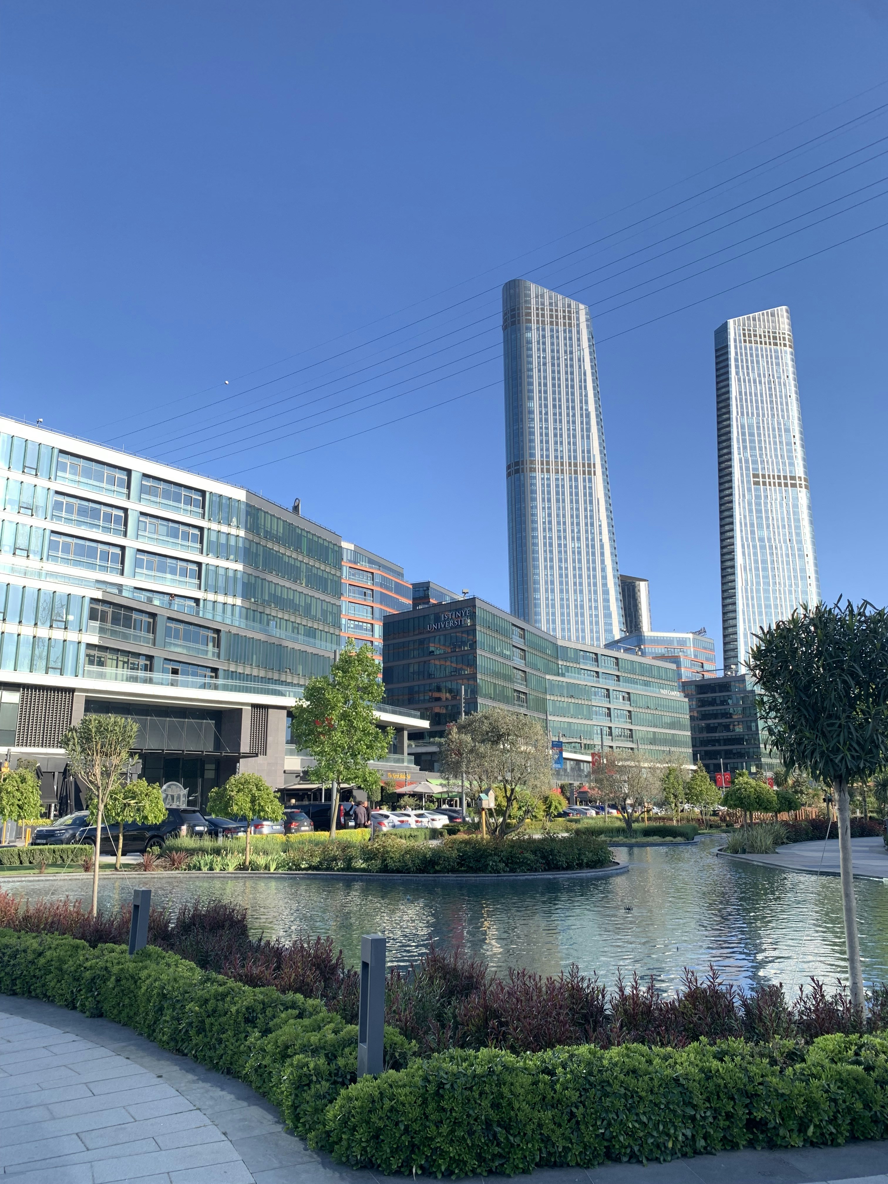 Twin Glass Towers Framing a Quiet Canal at a Modern Urban Campus