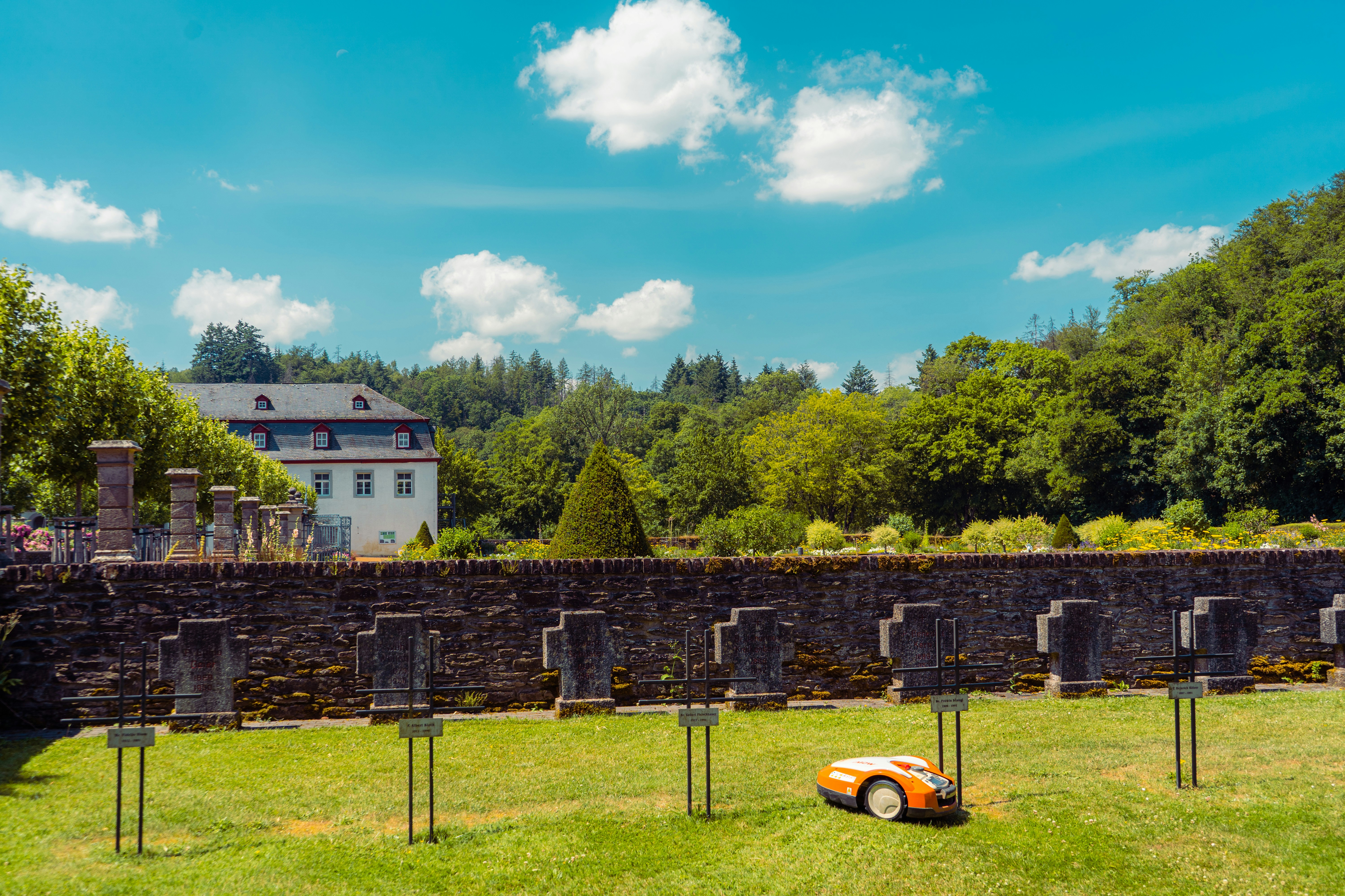 a lawn mower parked in front of a stone wall