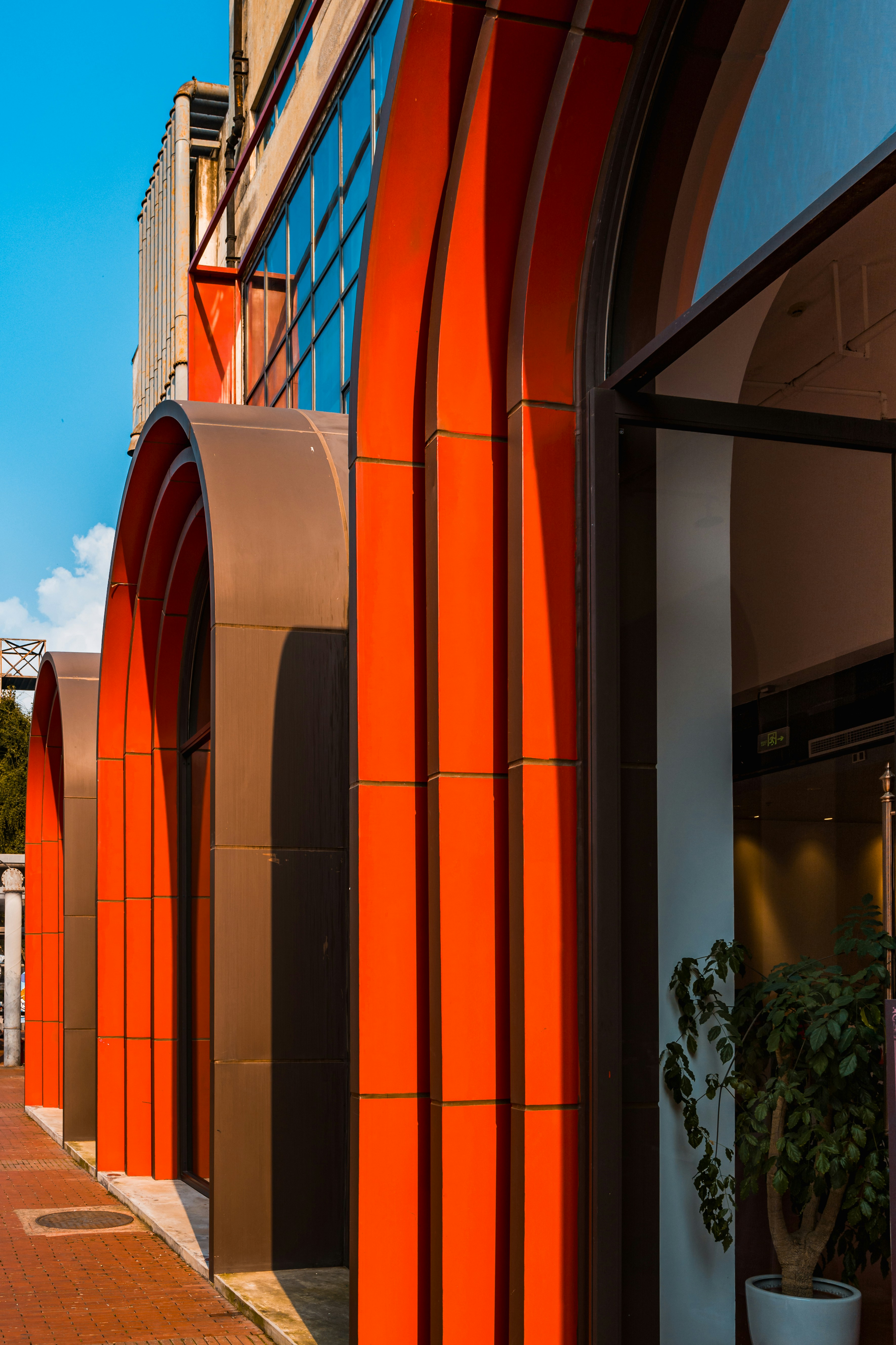 A row of orange arches on the side of a building photo – Free City ...