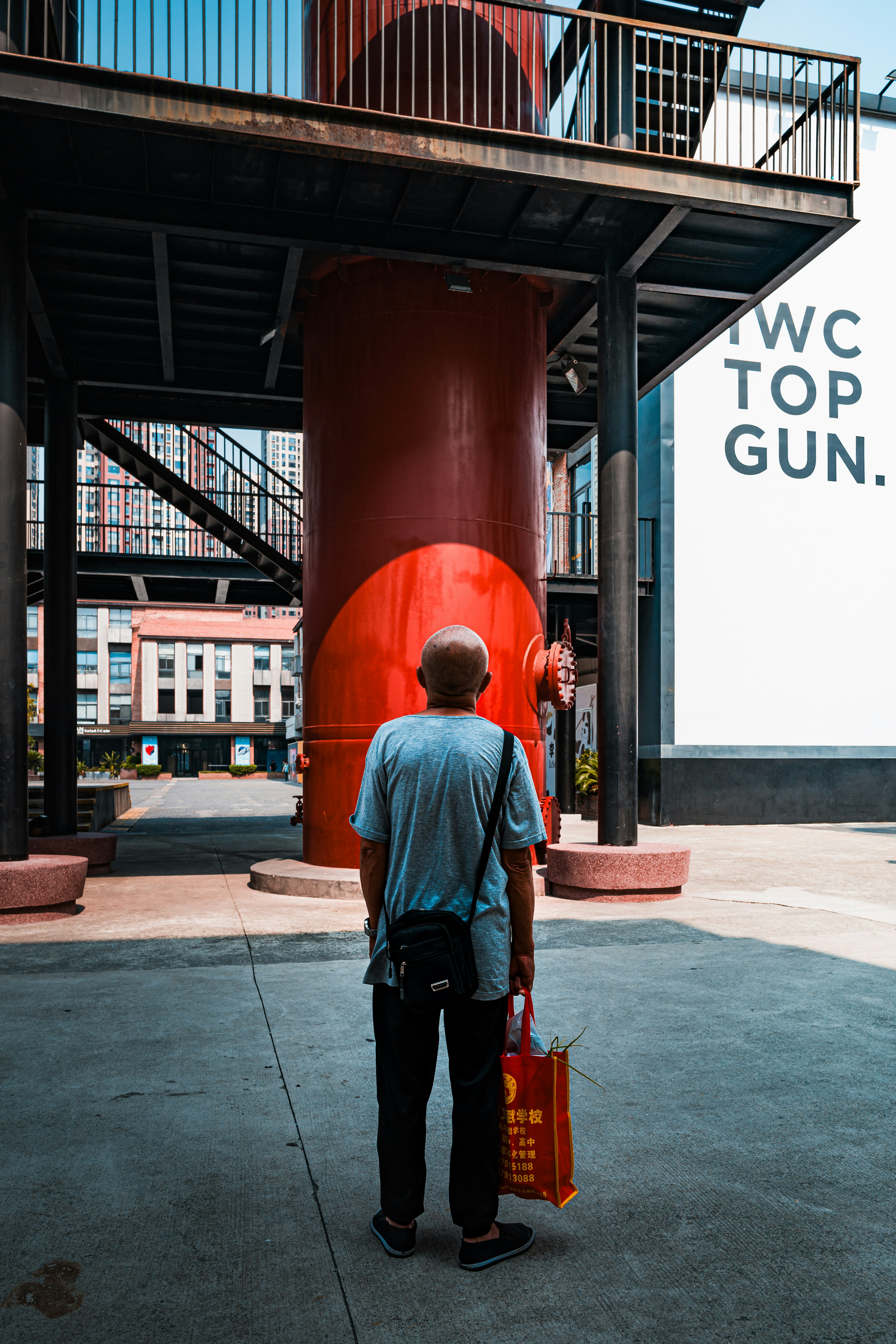 Un homme debout devant un objet rouge géant photo – Photo Rue Gratuite ...
