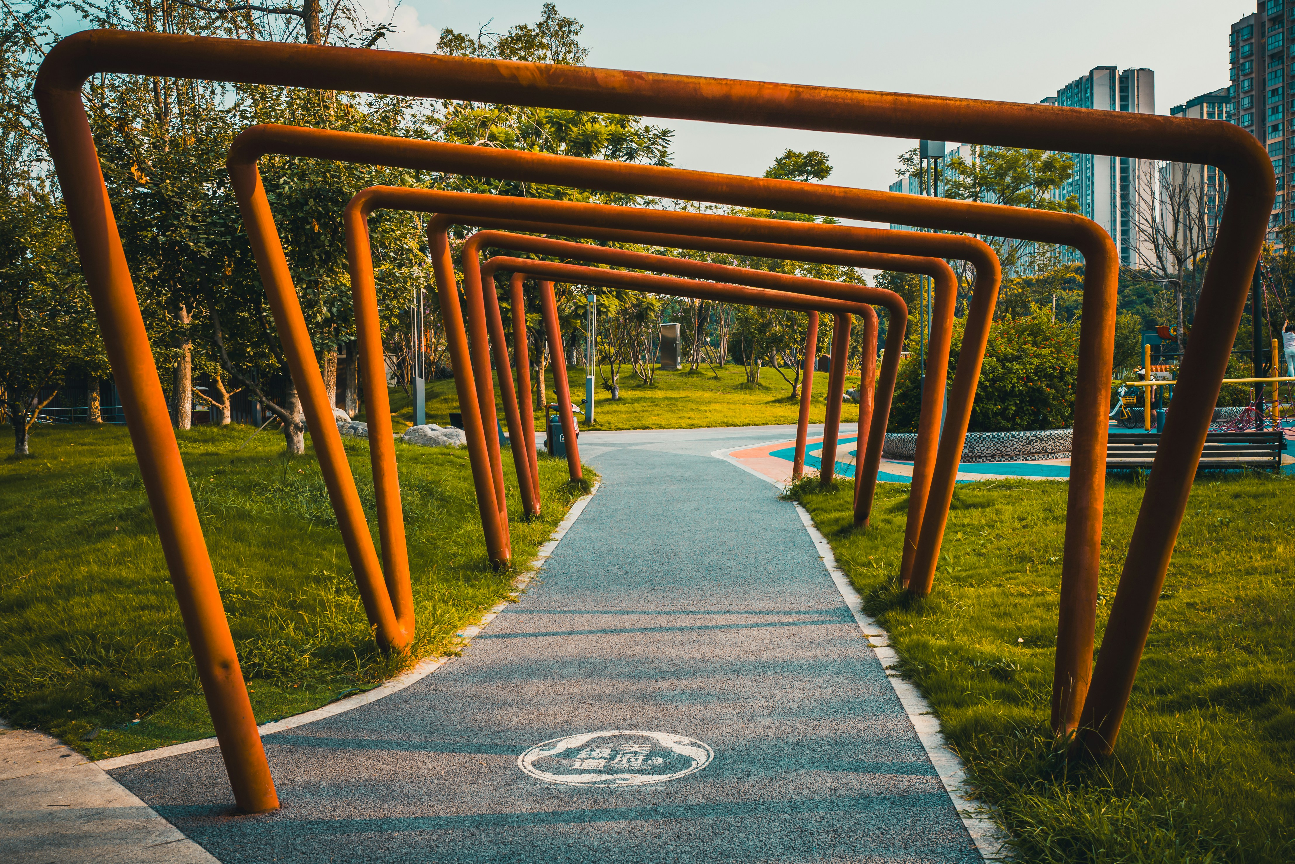A path with orange metal railings going through a park photo – Free ...