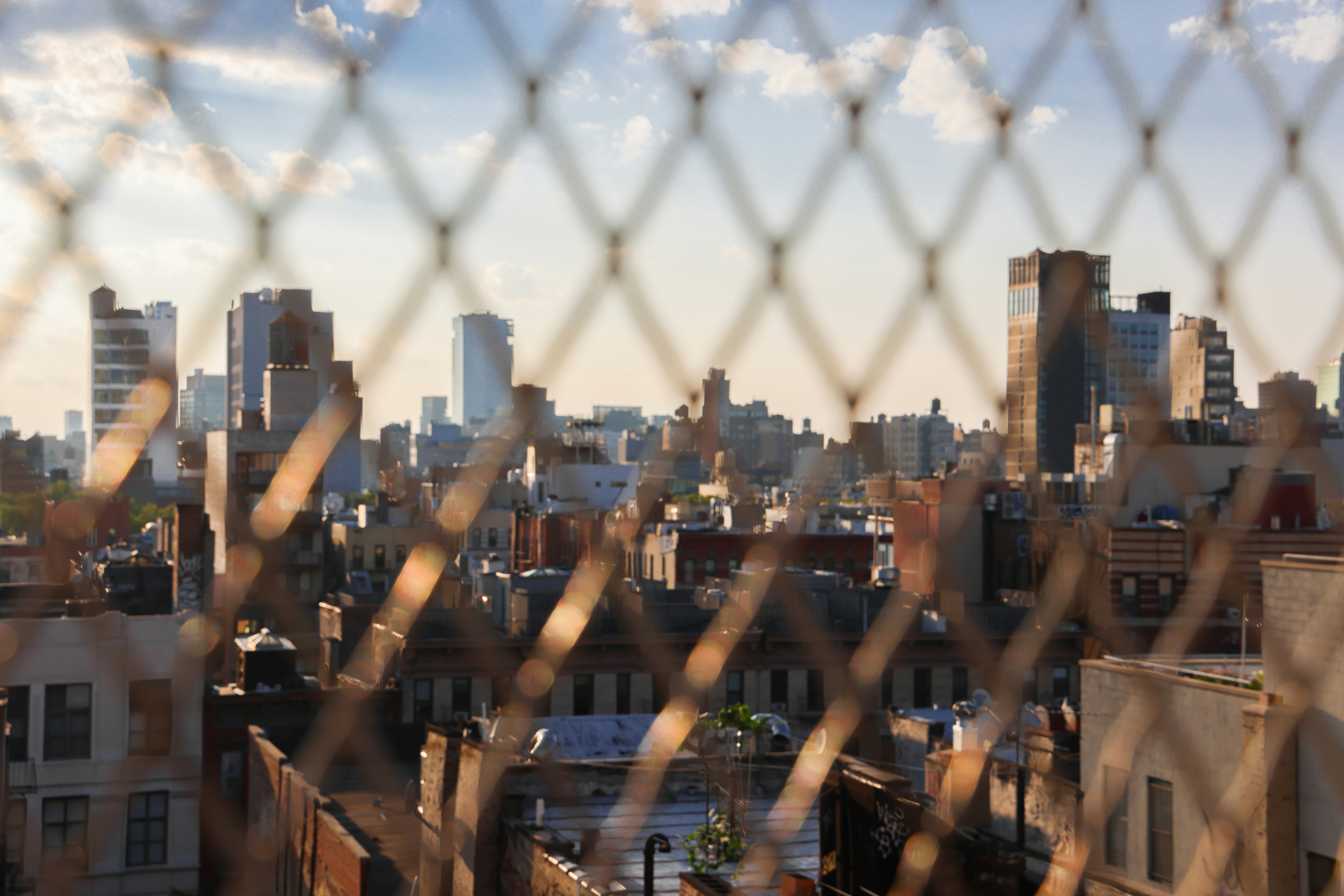 Veiled Skyline Through a Chain-Link Veil at Dusk