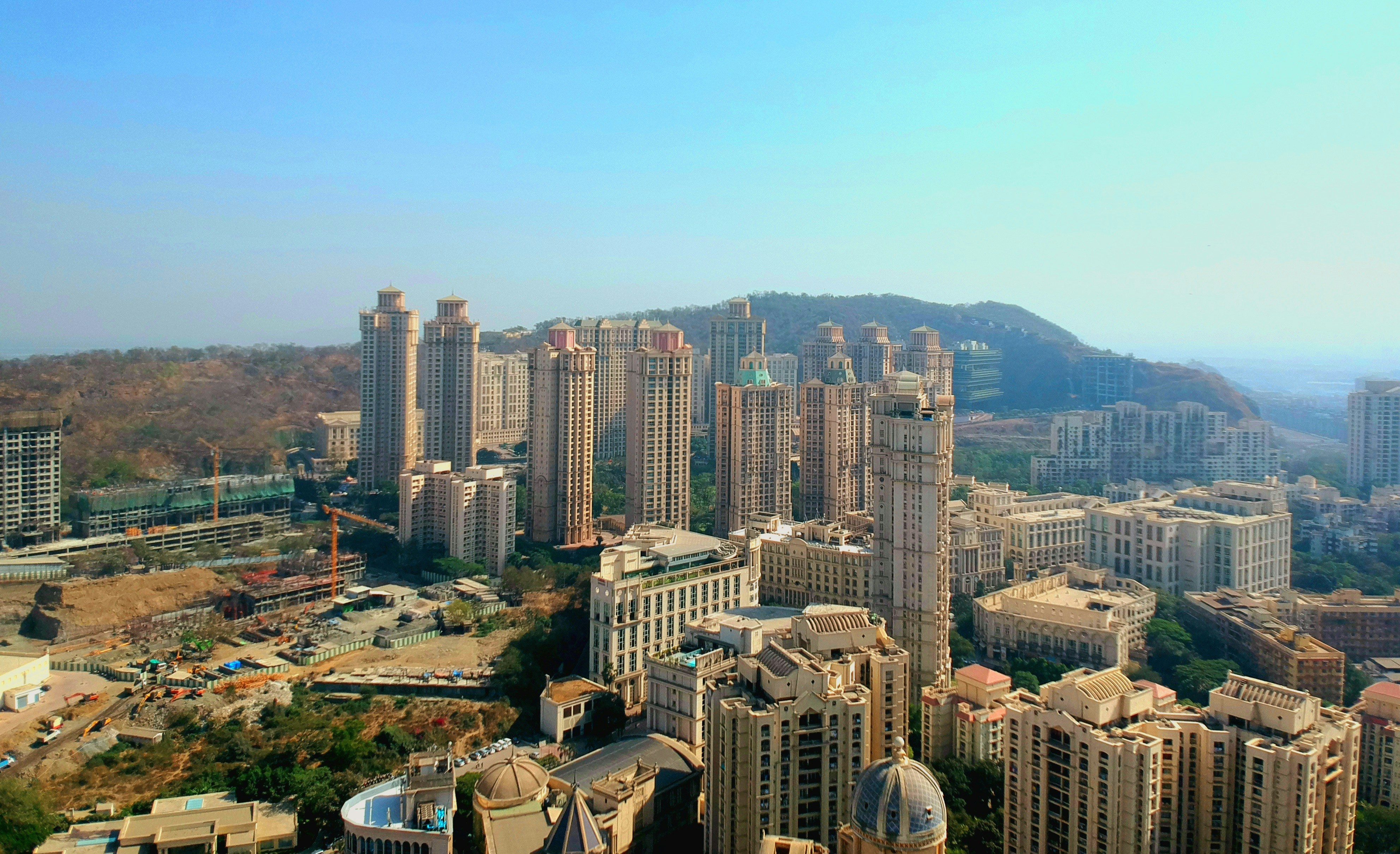 High-rise buildings of Hiranandani Gardens set against a clear blue sky.