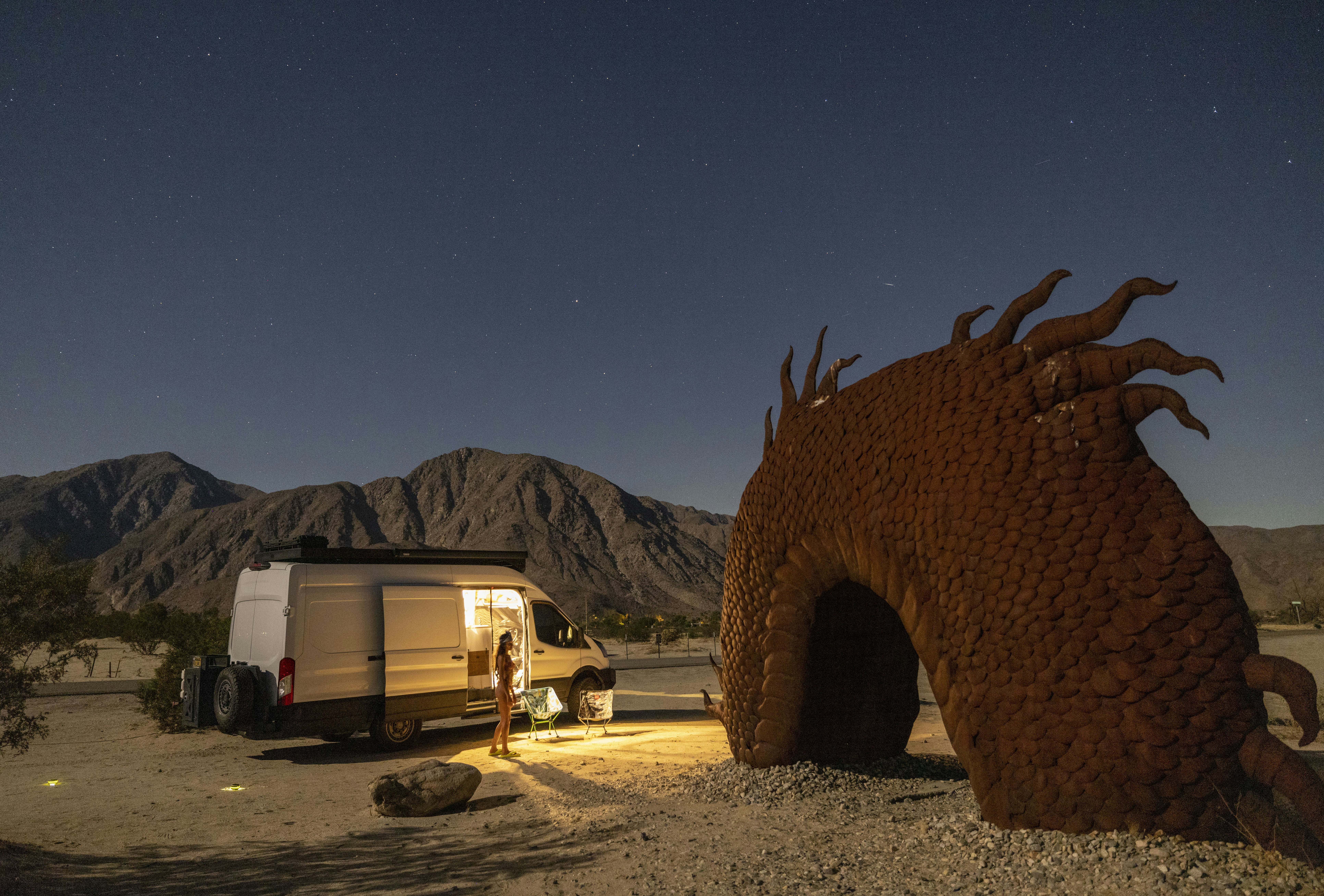 A camper trailer parked next to a dragon like structure photo – Free ...