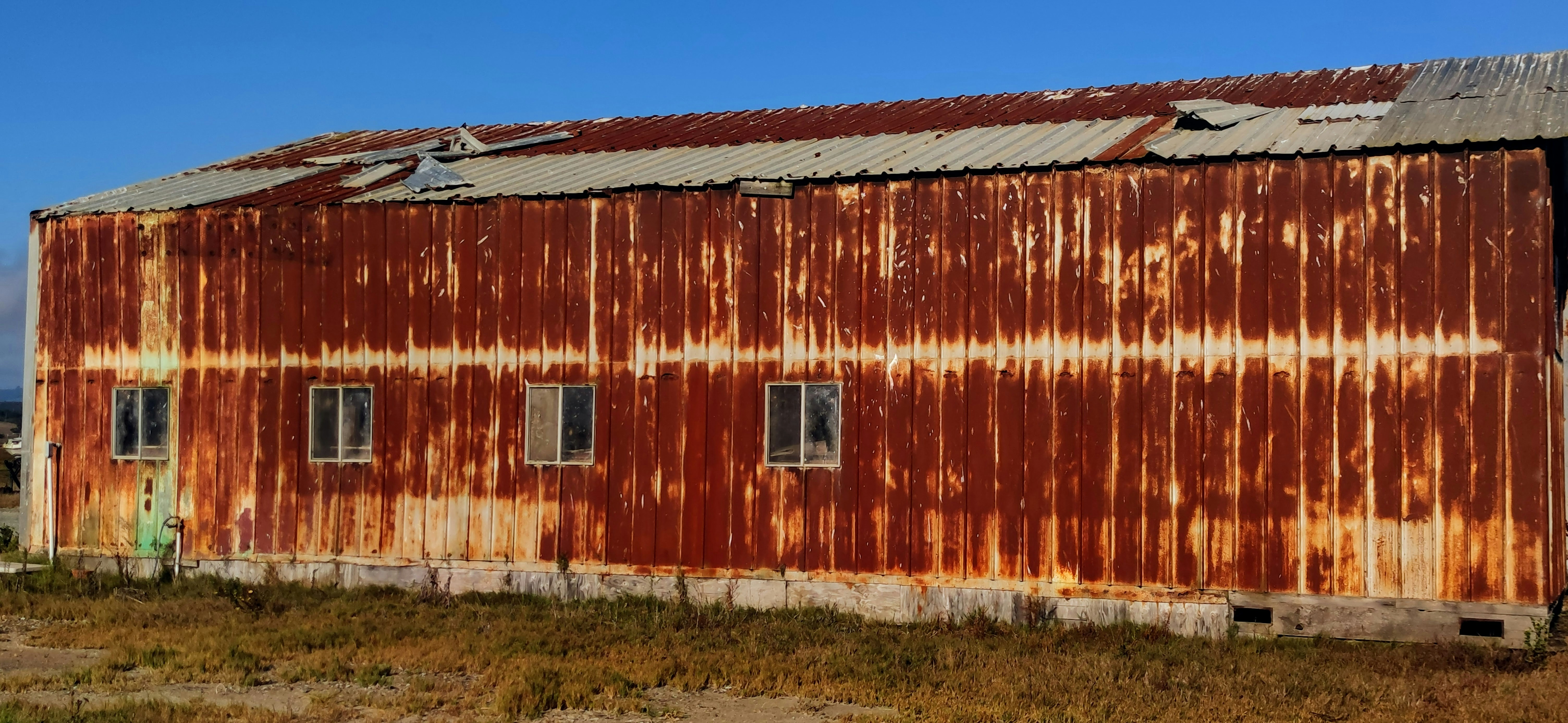 an old rusted metal building in the middle of nowhere