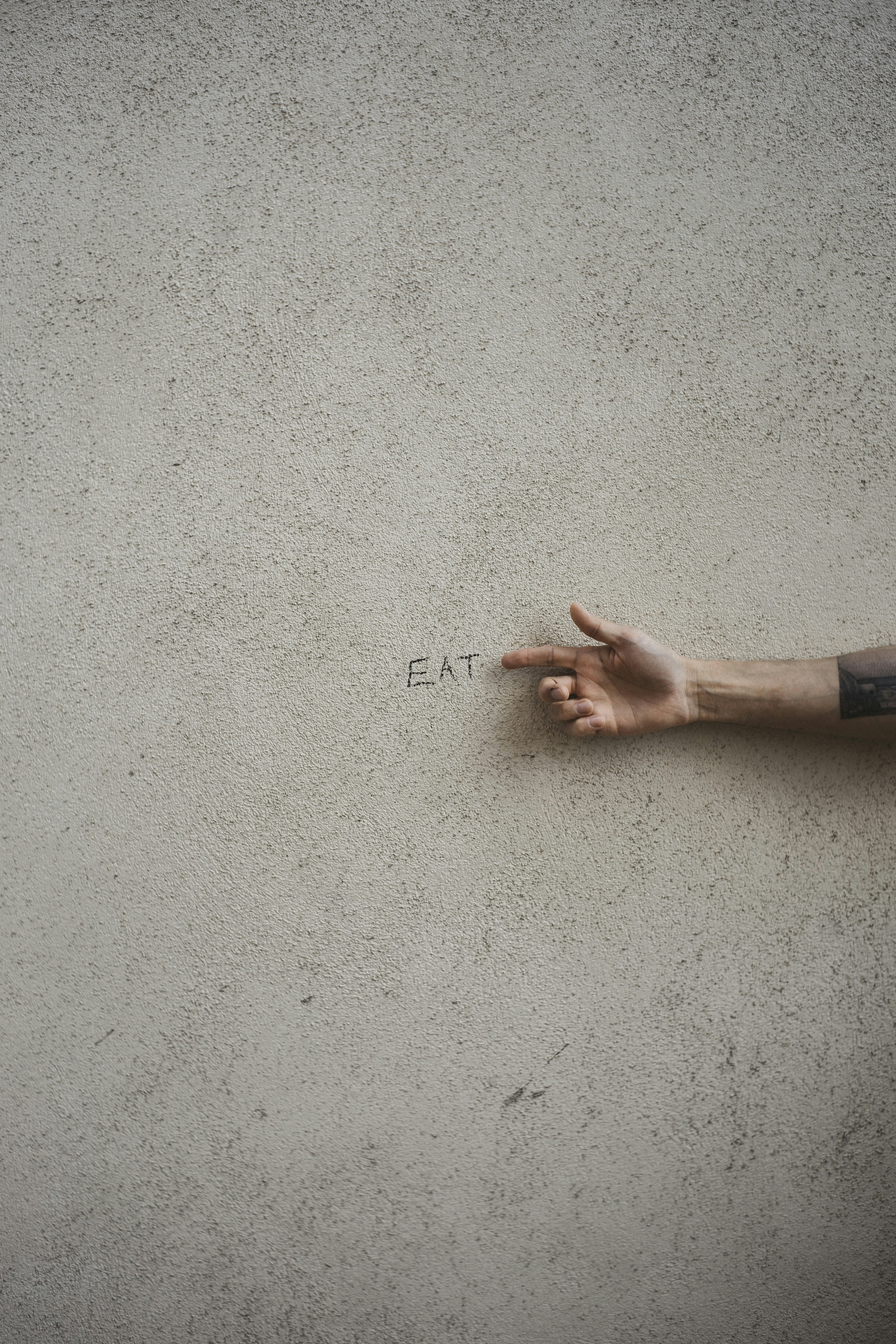 Fingertip at the Edge of EAT on a Quiet Concrete Canvas