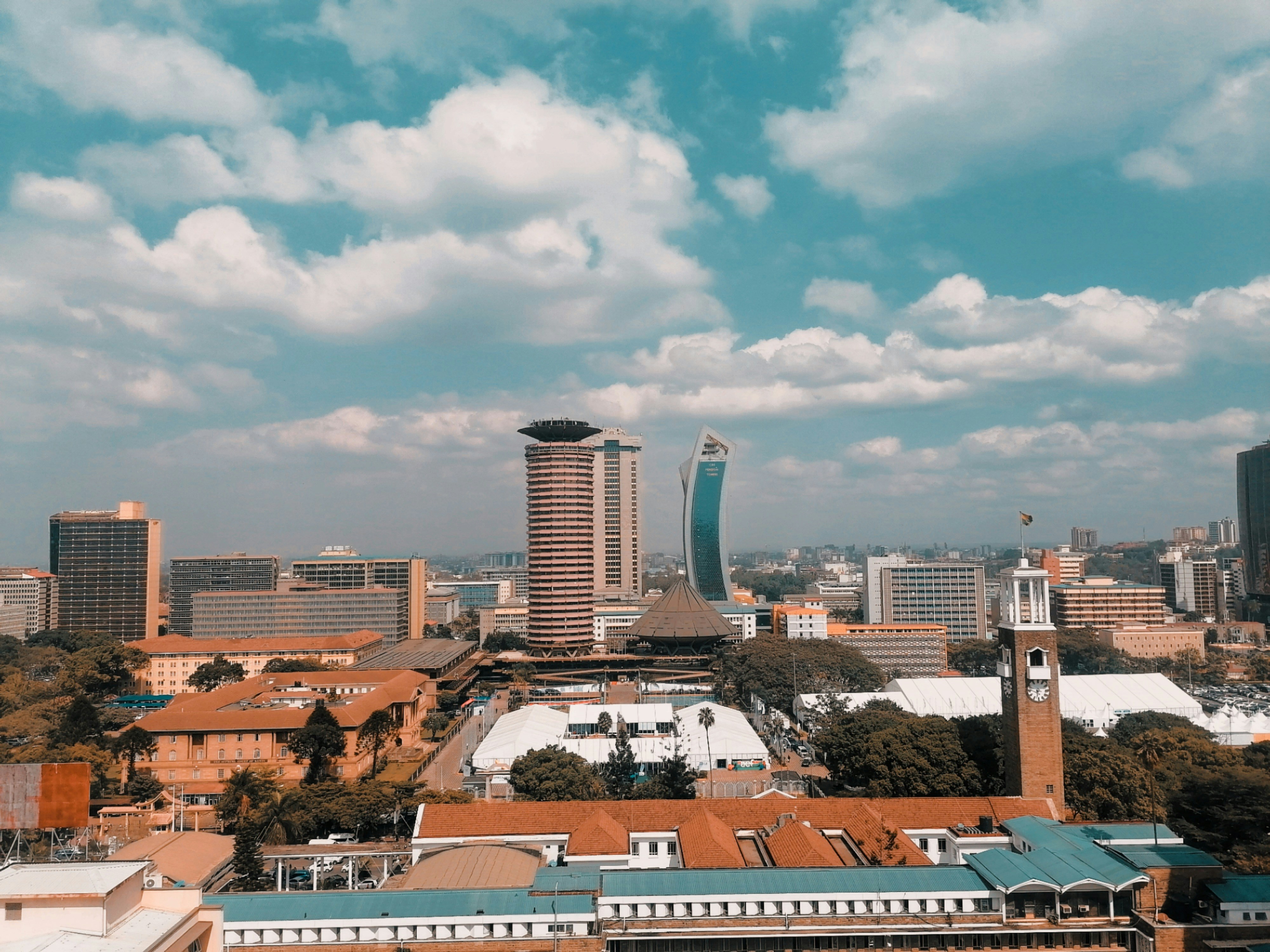 A panoramic view of Nairobi's skyline showcasing a blend of modern architecture and lush greenery under a vibrant sky.