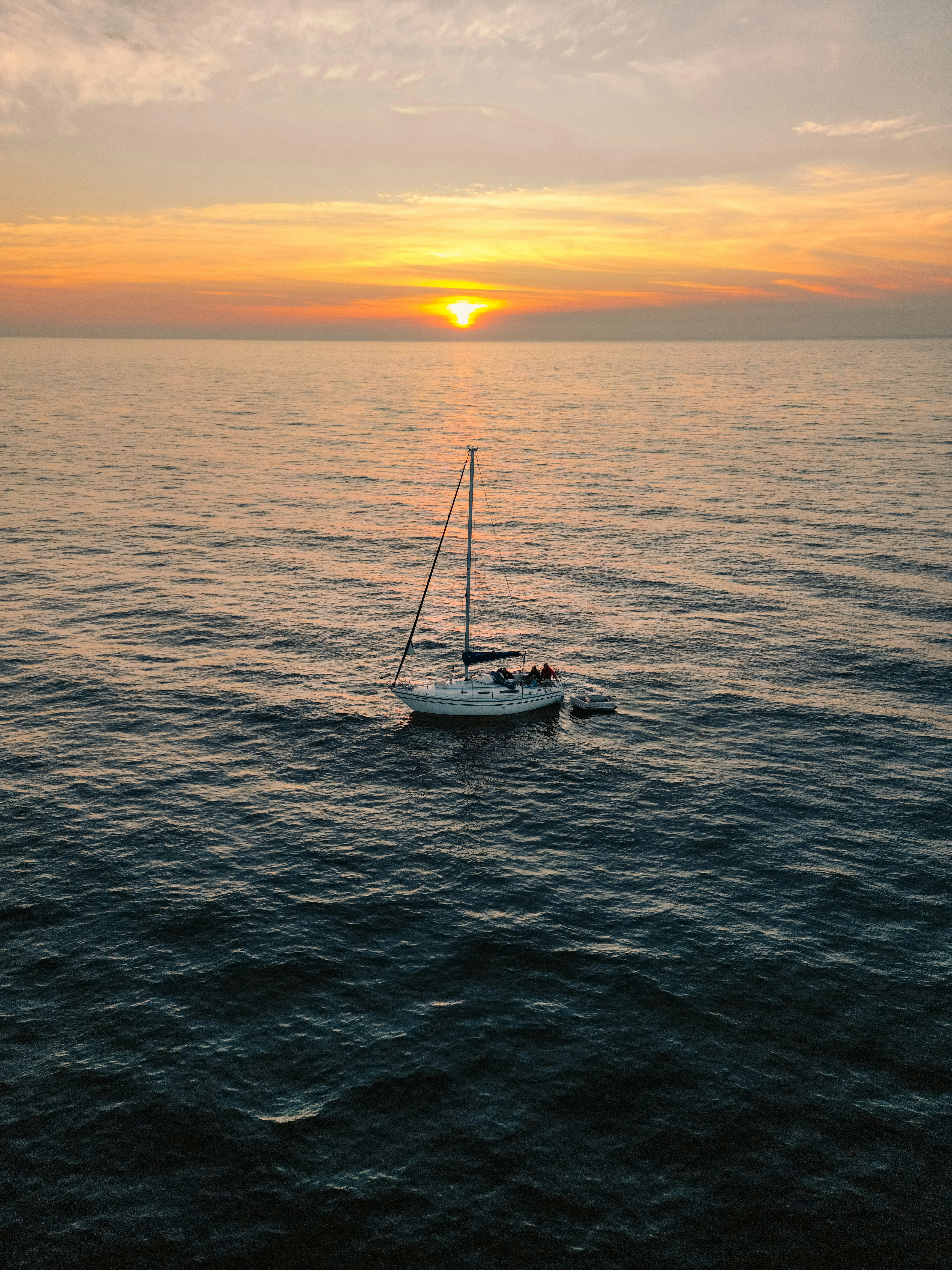 A sailboat in the middle of the ocean at sunset photo – Free Aberaeron ...