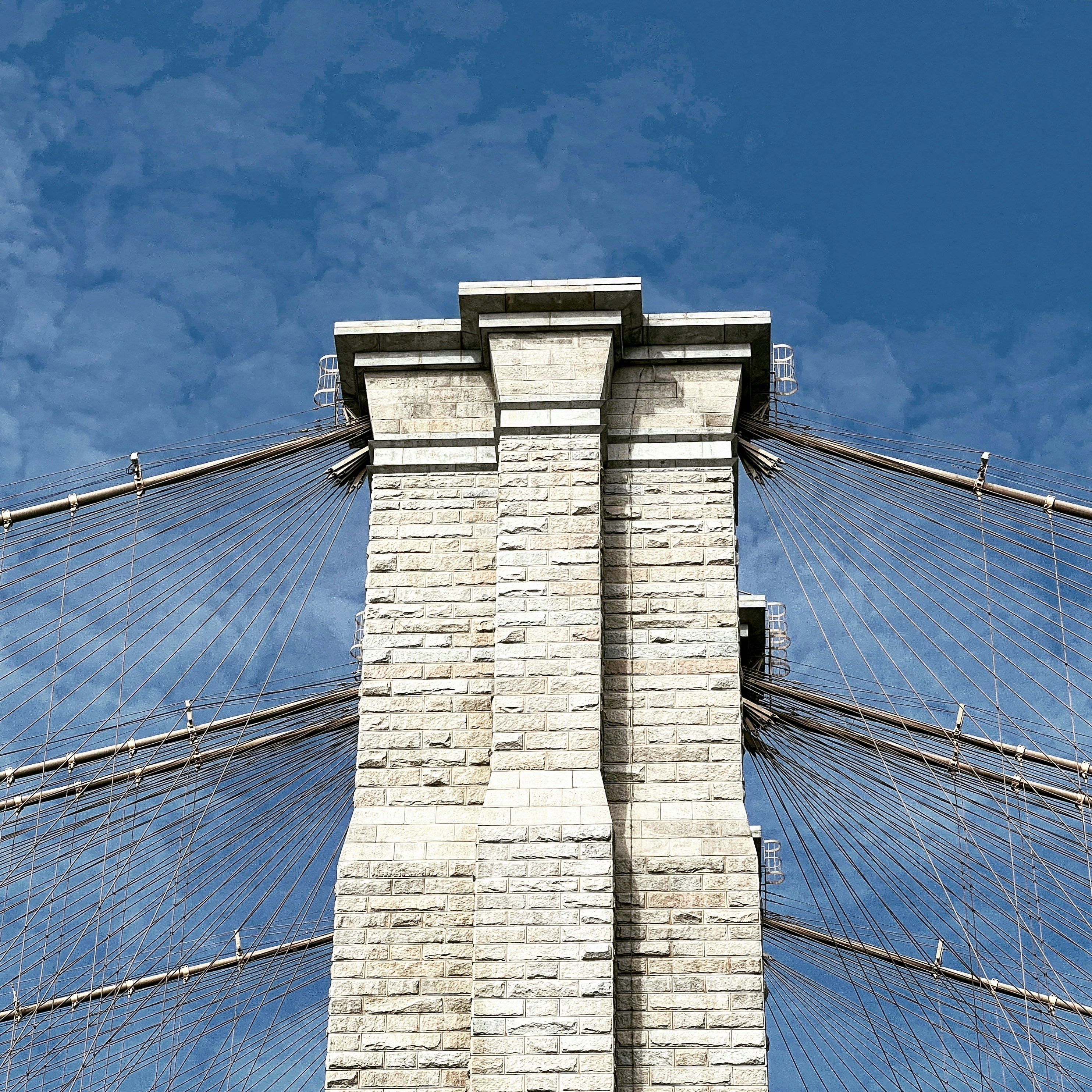 Stone Sentinel Framed by Radiating Cables Across a Deep Blue Sky