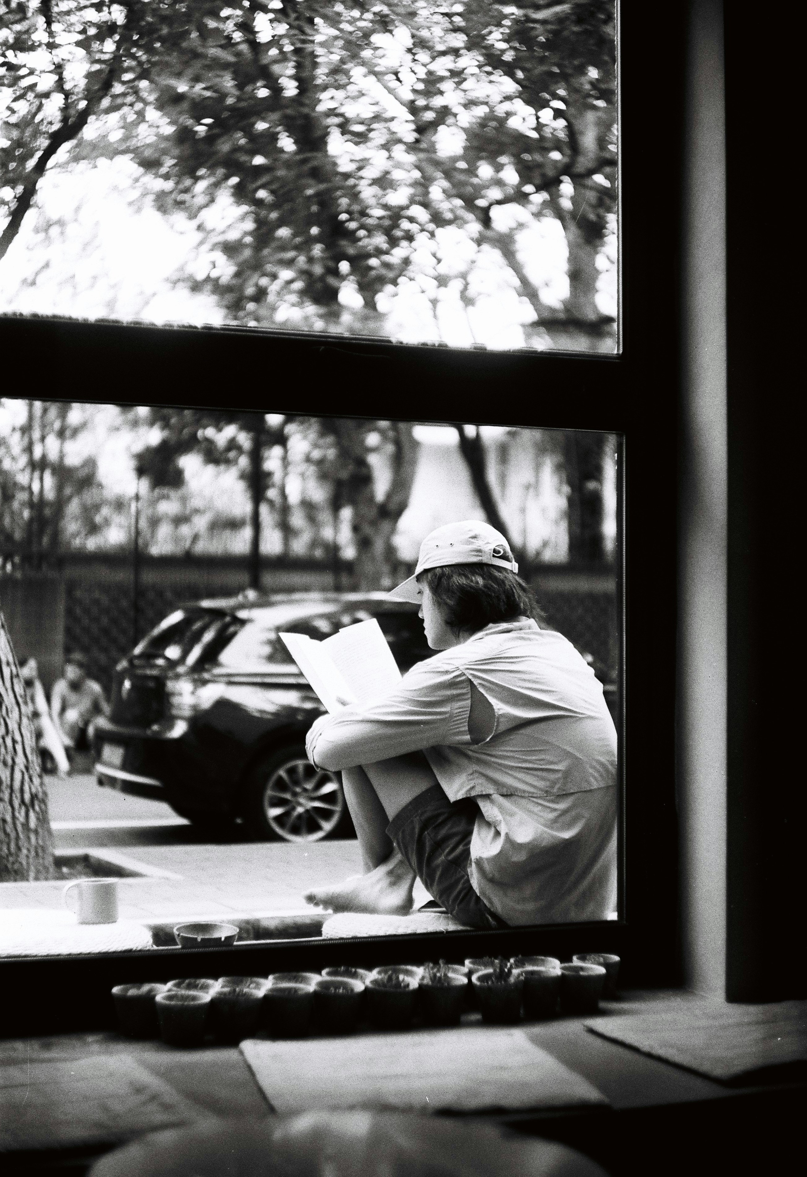 Lone Reader by the Window: Quiet Contemplation in Soft Focus