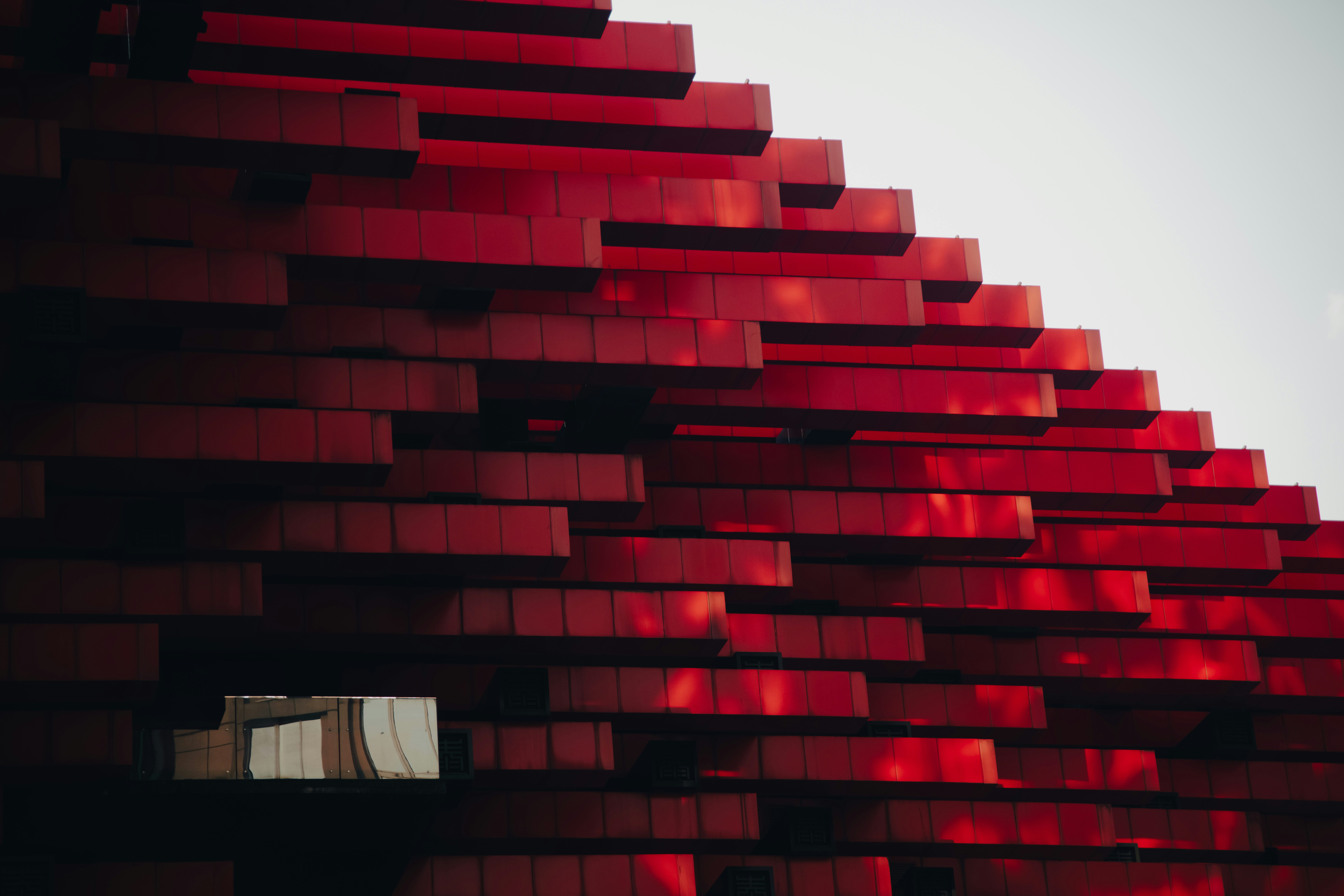Crimson Blockwork: A Window Hidden Within Layered Red Facades