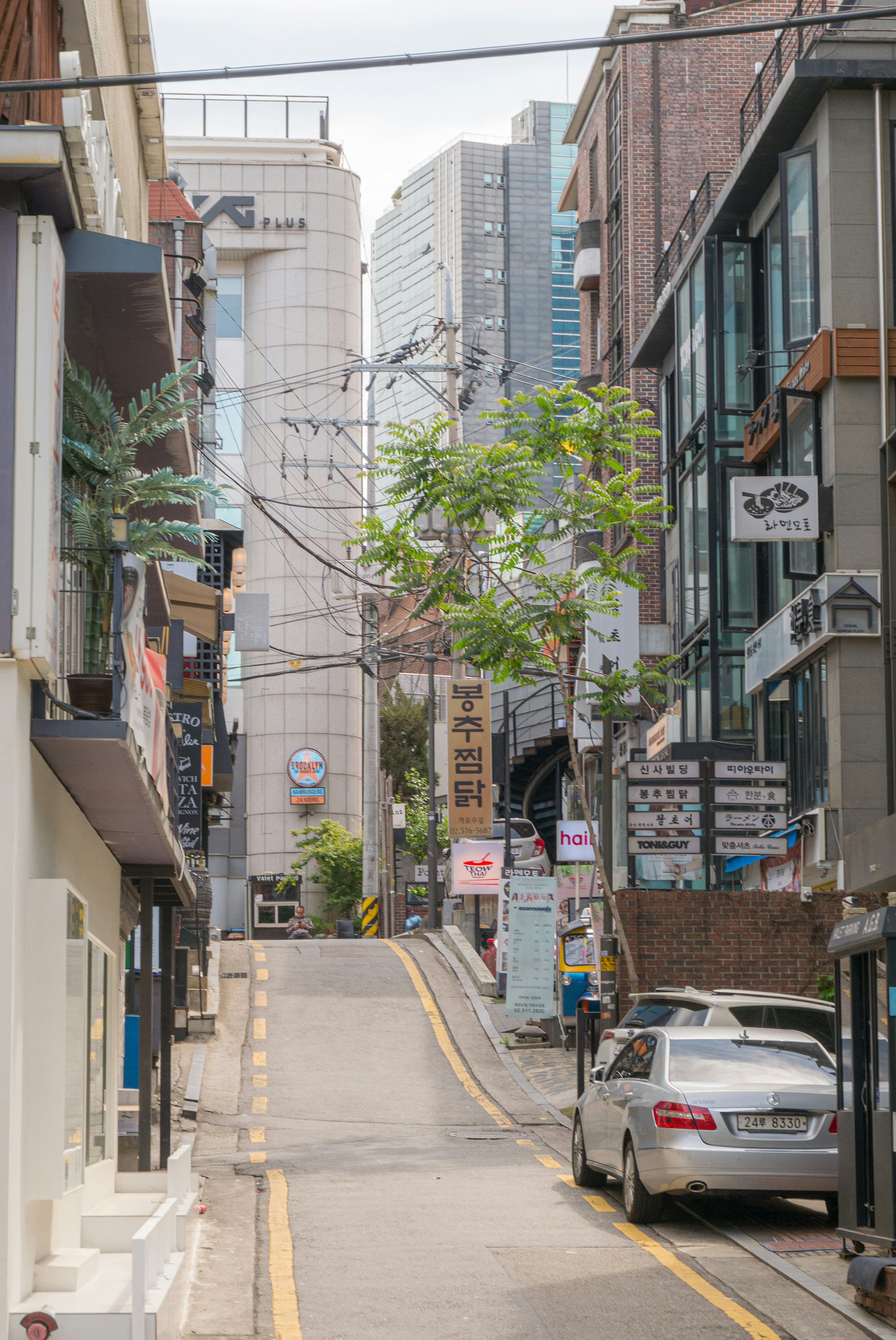 Ascending Alley: Signs and Towers Framing a Quiet City Climb