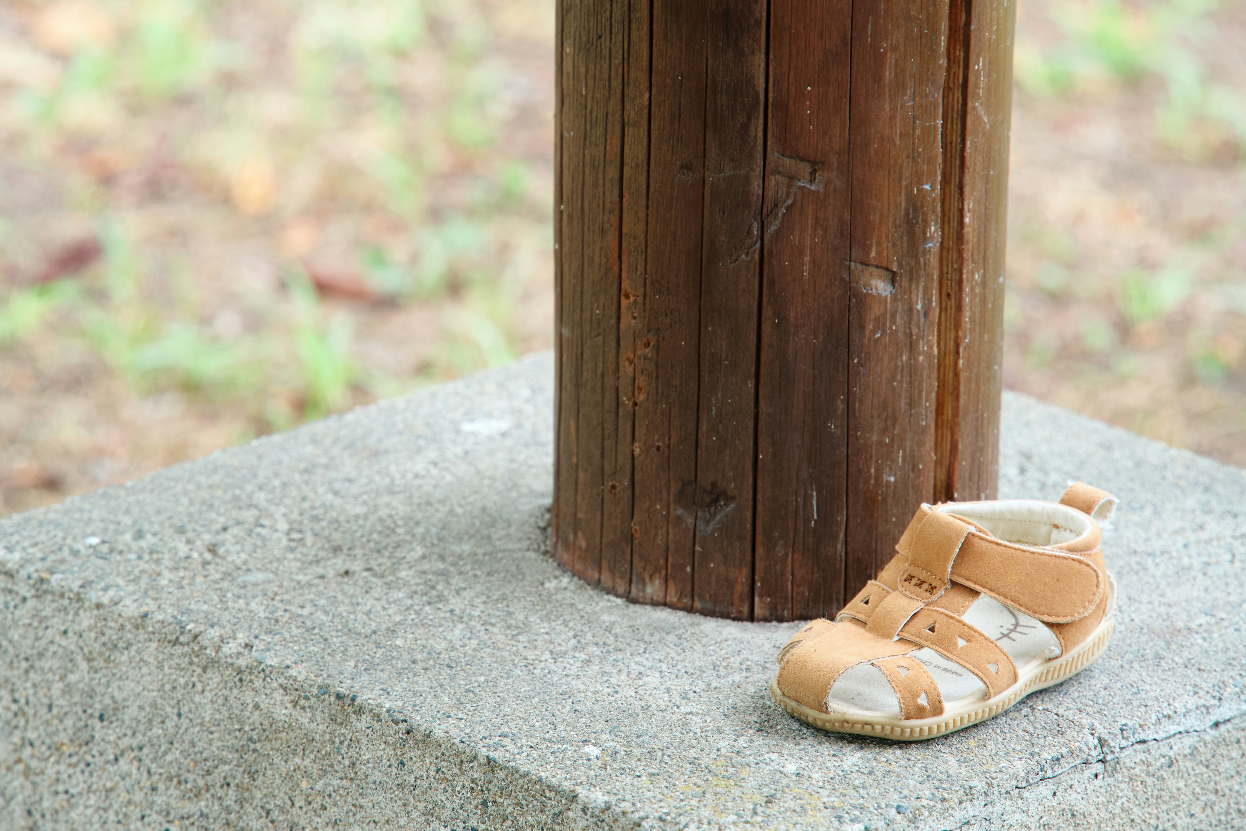 Tiny Sandals at the Base of a Weathered Post