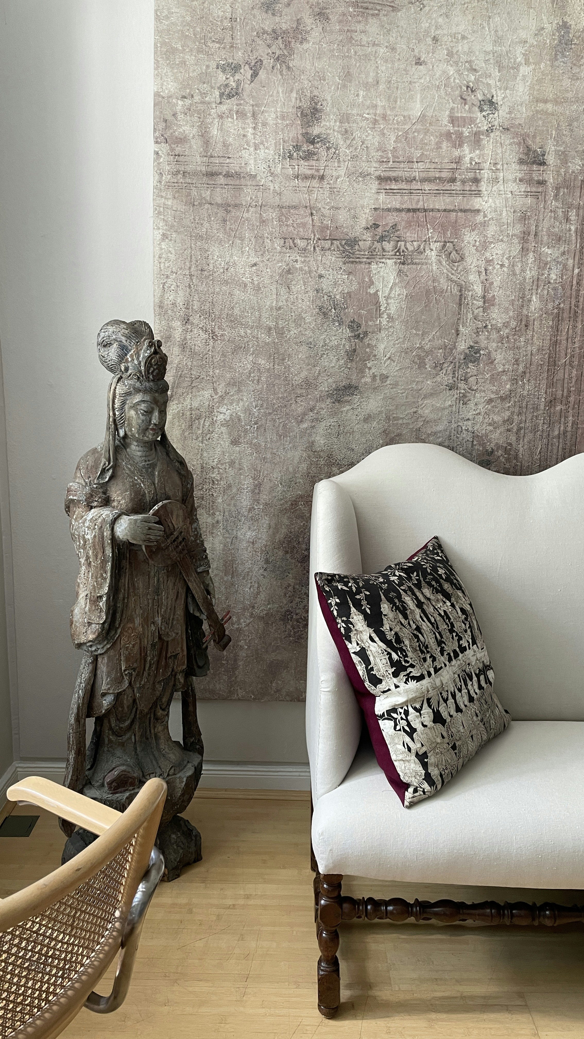 Stone Sentinel by the Sofa: An Antique Figure in a Quiet Living Corner