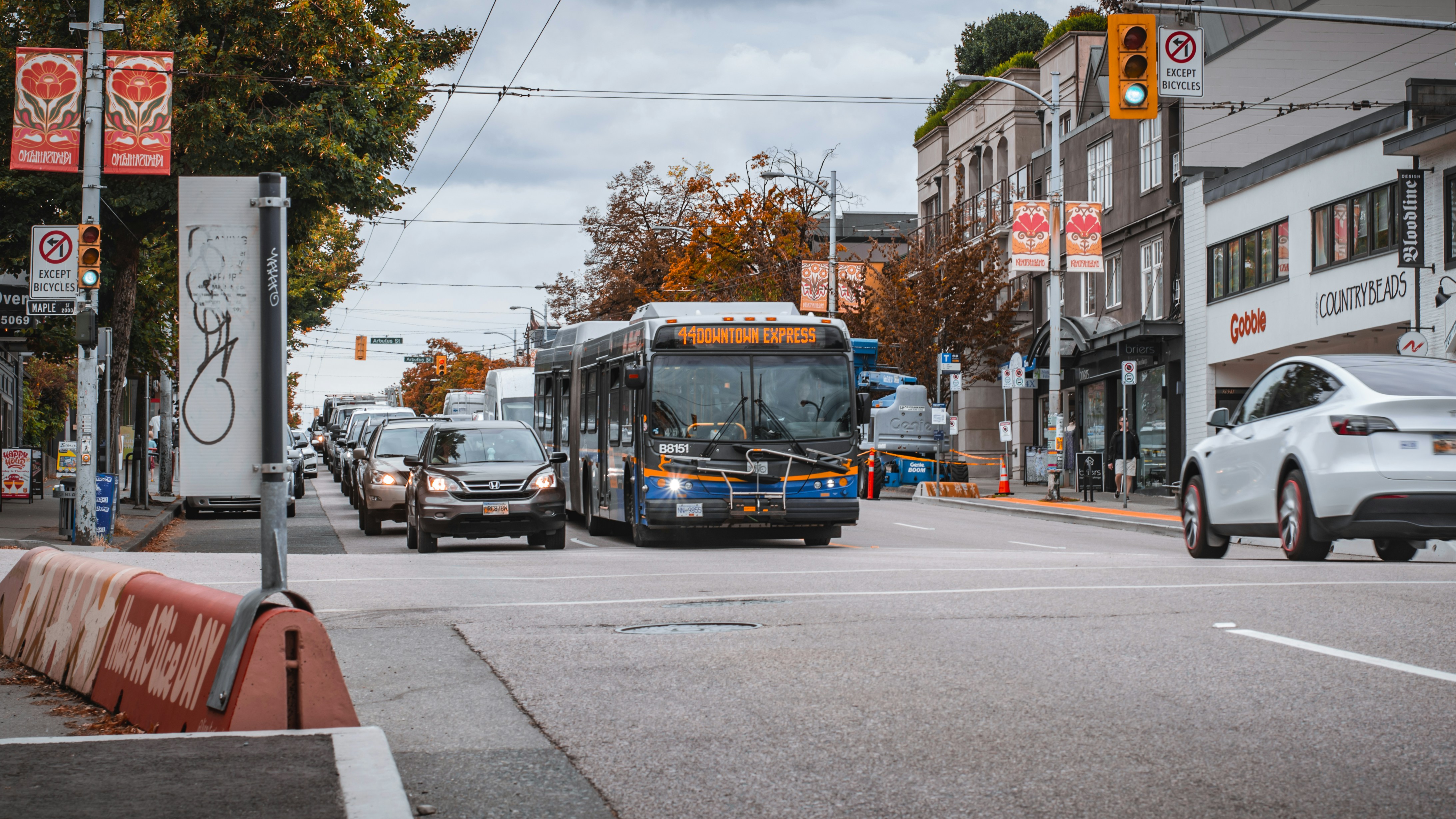A city bus driving down a street next to tall buildings photo – Free ...
