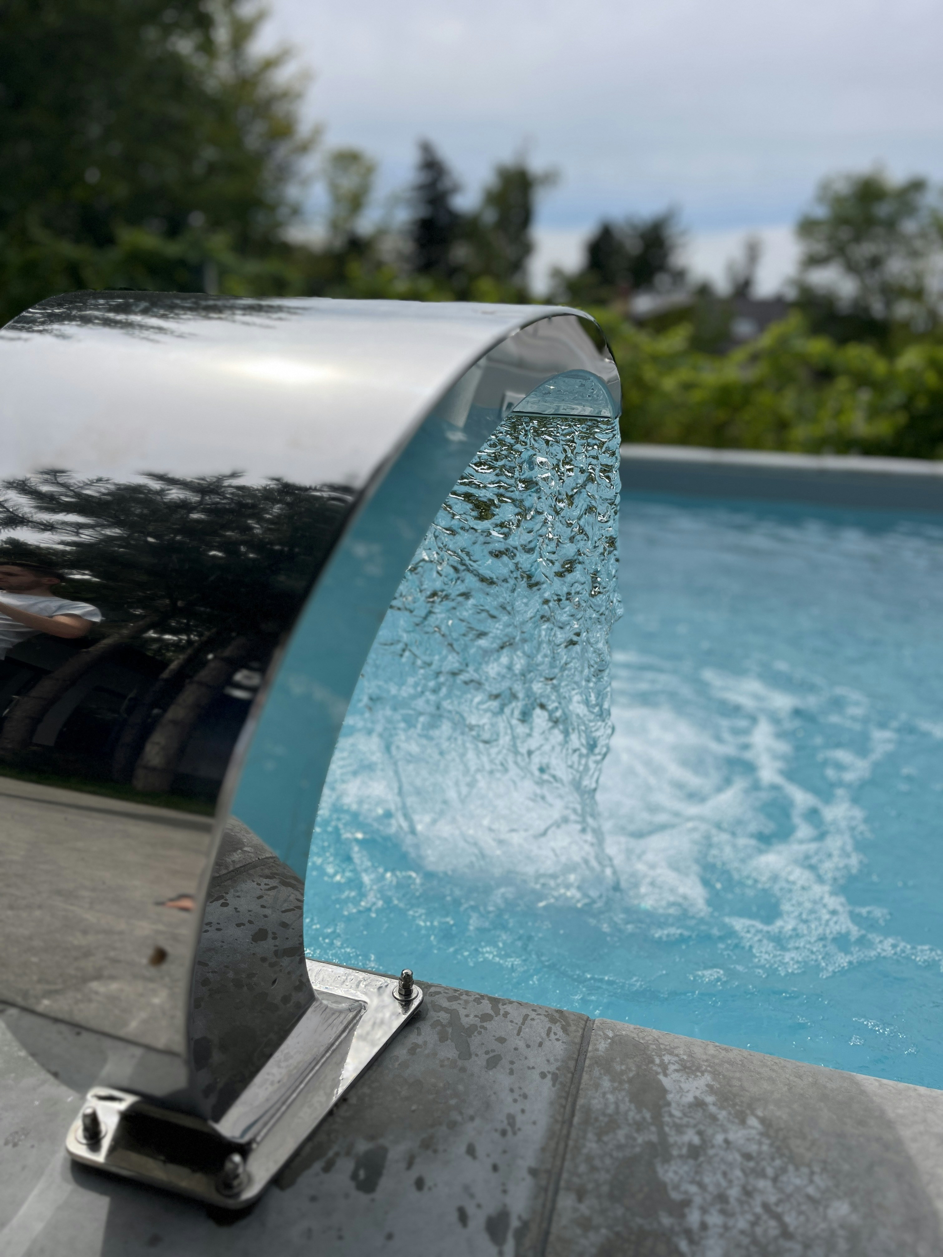 A pool with a water feature in the middle of it photo – Free Waterfall ...