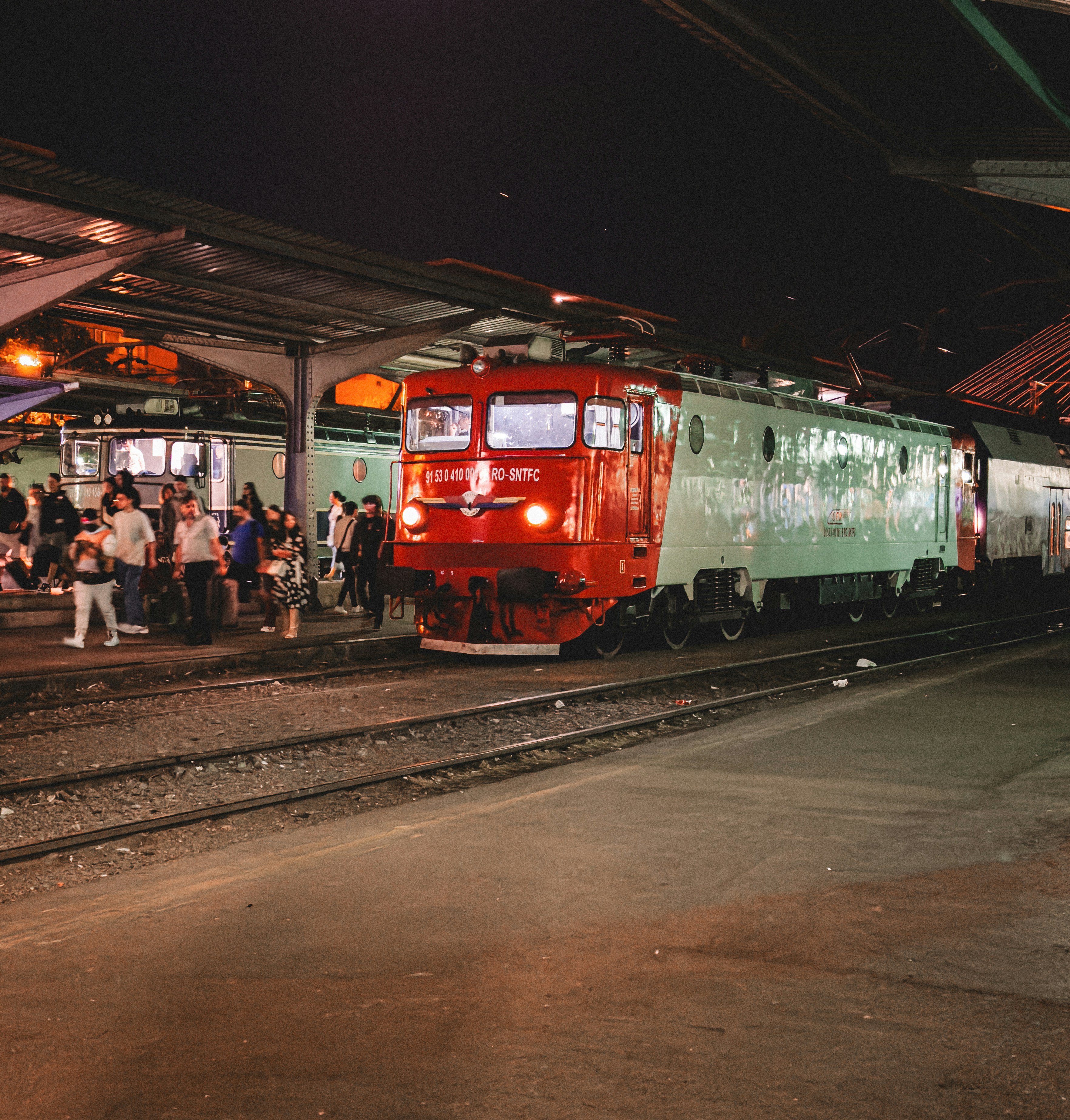 A red and green train pulling into a train station photo – Free Gara de ...