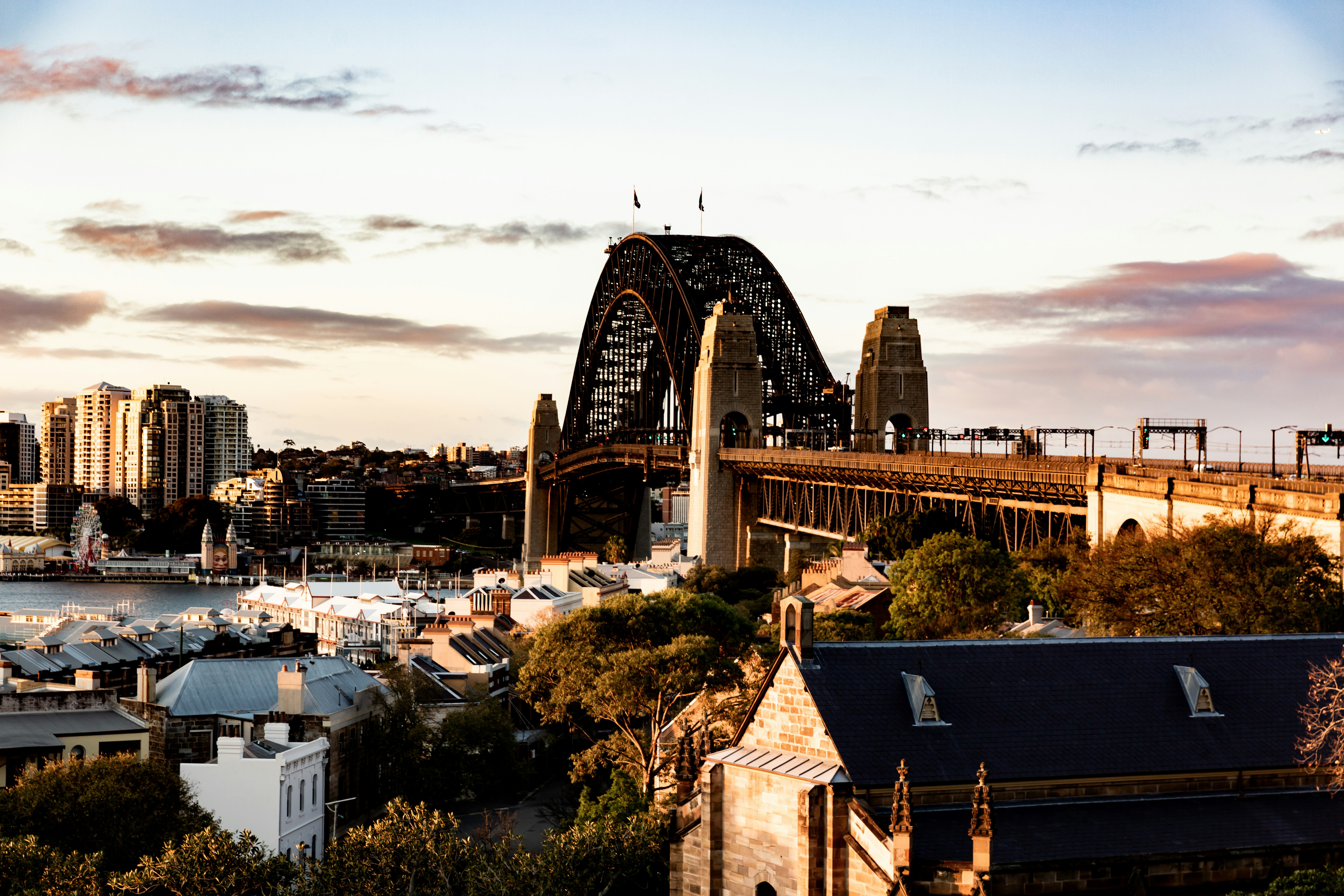 Dusk Arch Over the City: A Steel Span Framing Rooftops in Amber Light