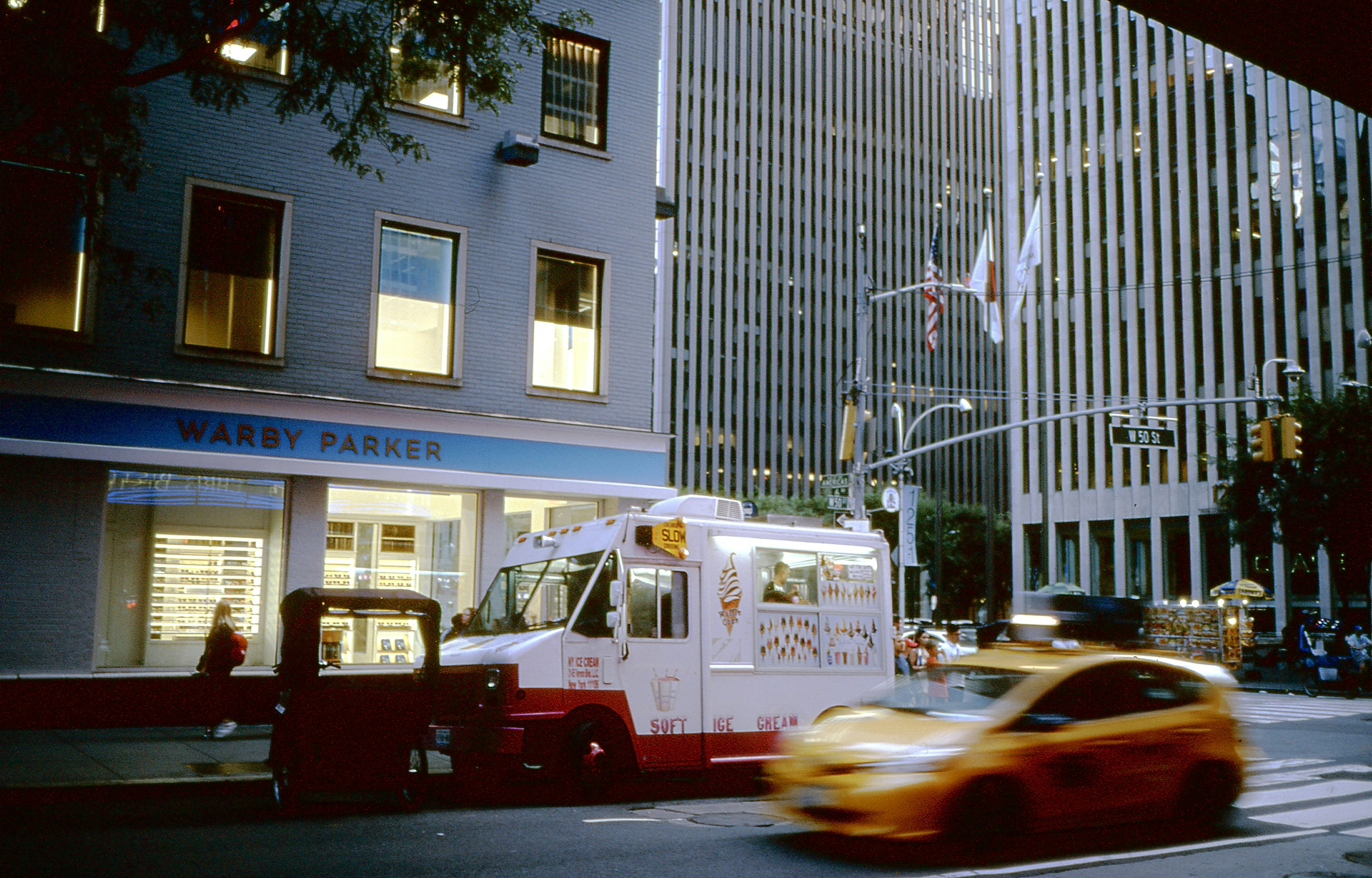 Un camion roulant dans une rue à côté de grands immeubles photo – Image ...