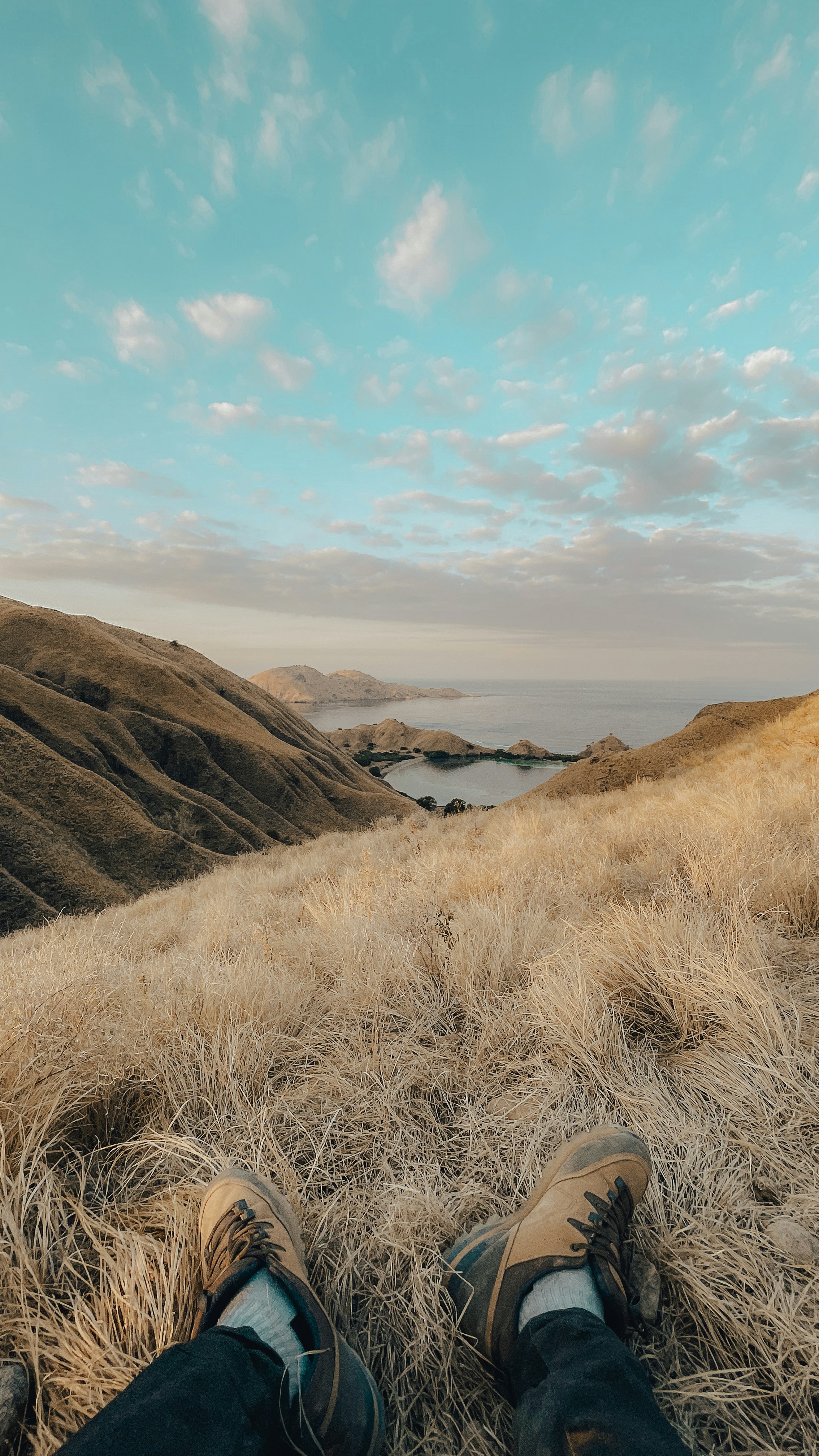 Boots at the Rim: A Golden Hills Overlooking a Quiet Sea