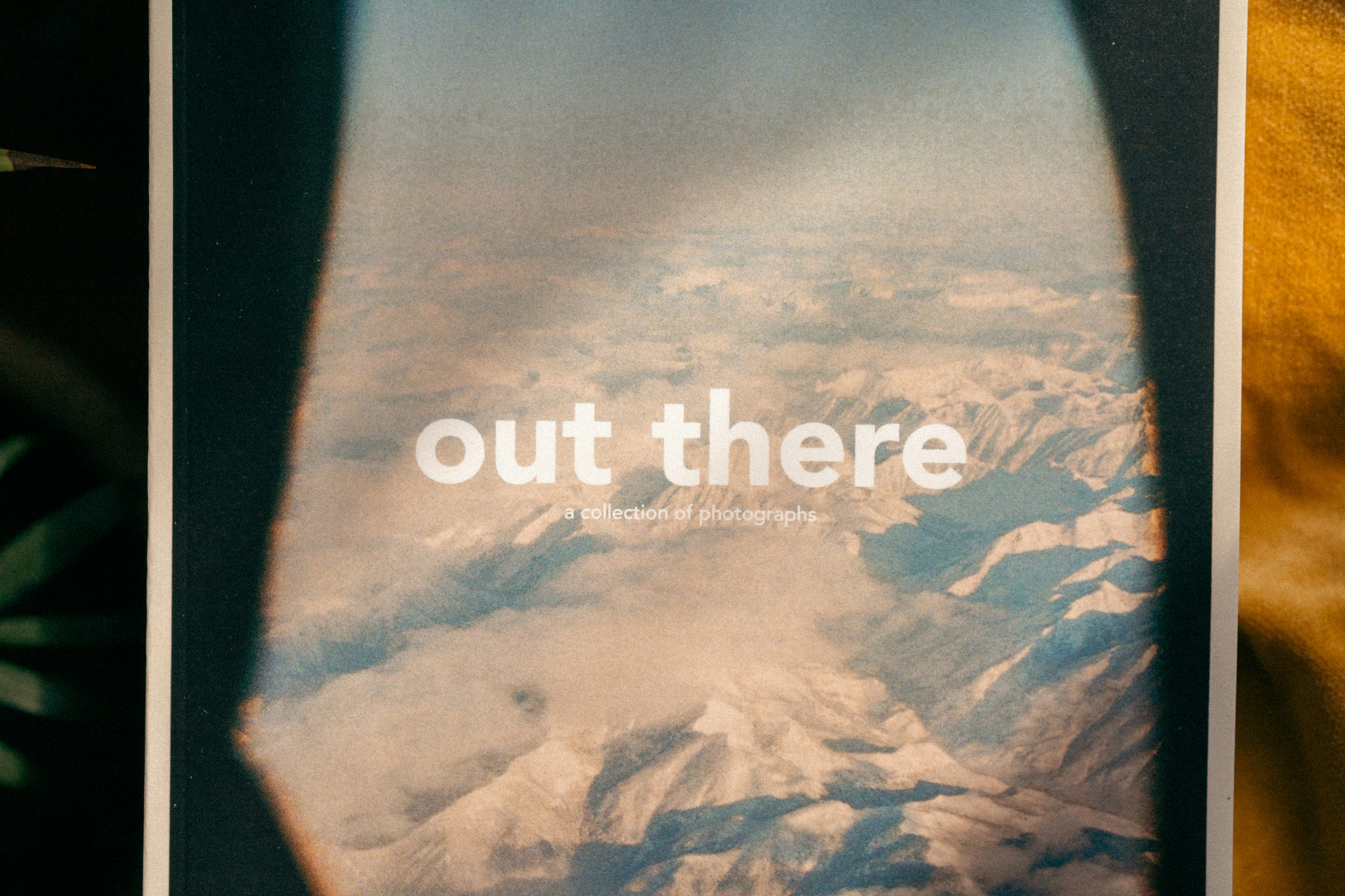 This is my new zine, a collection of photographs taken while traveling around the world! Tap the link here on Unsplash to grab yourself a copy. | a picture of a view of a mountain range with the words out there on it