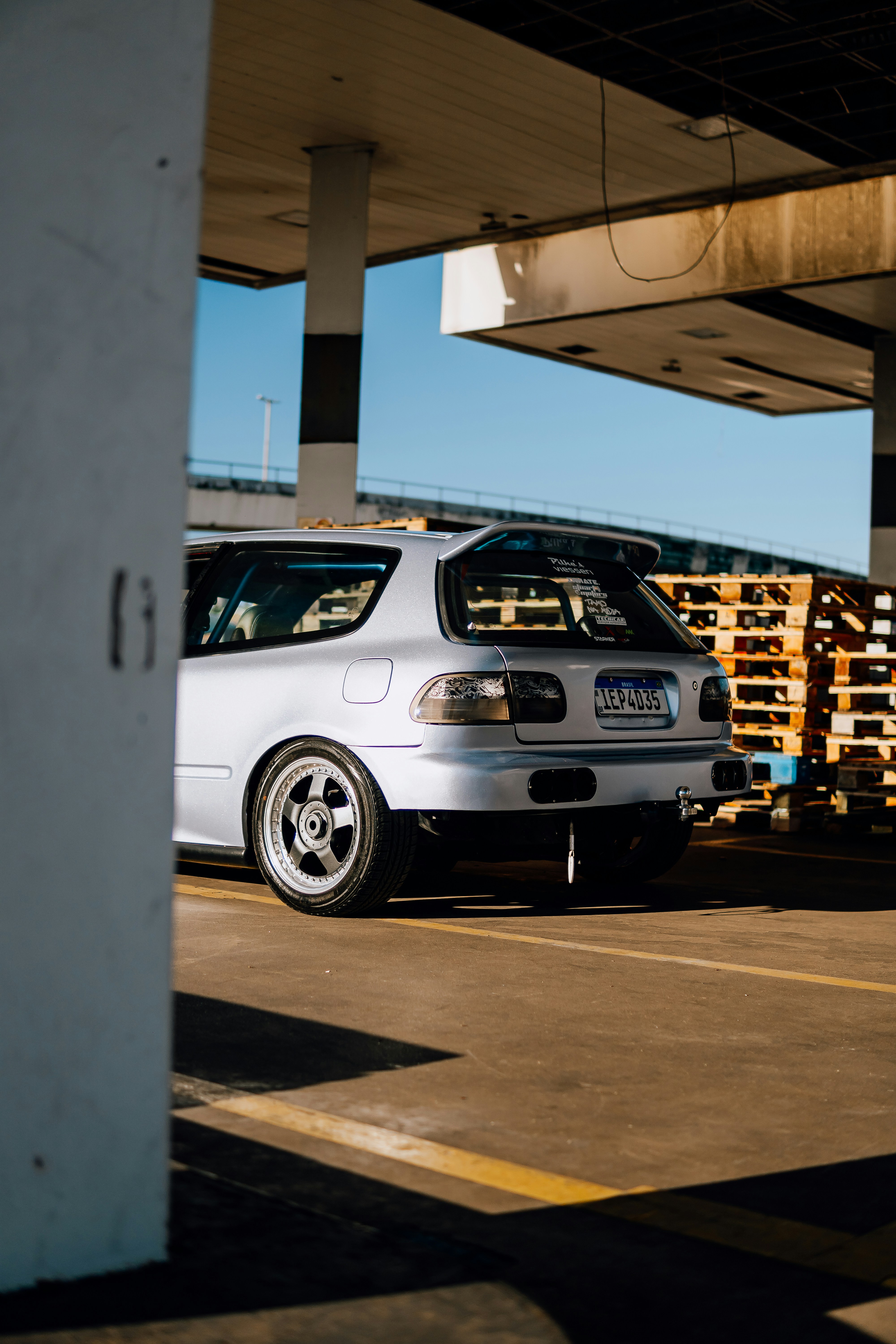 Concrete Shadows and Chrome: A Silver Hatch in the Parking Garage
