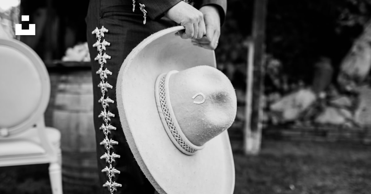 Un Hombre Con Traje Y Sombrero Parado Junto A Una Silla Foto Imagen