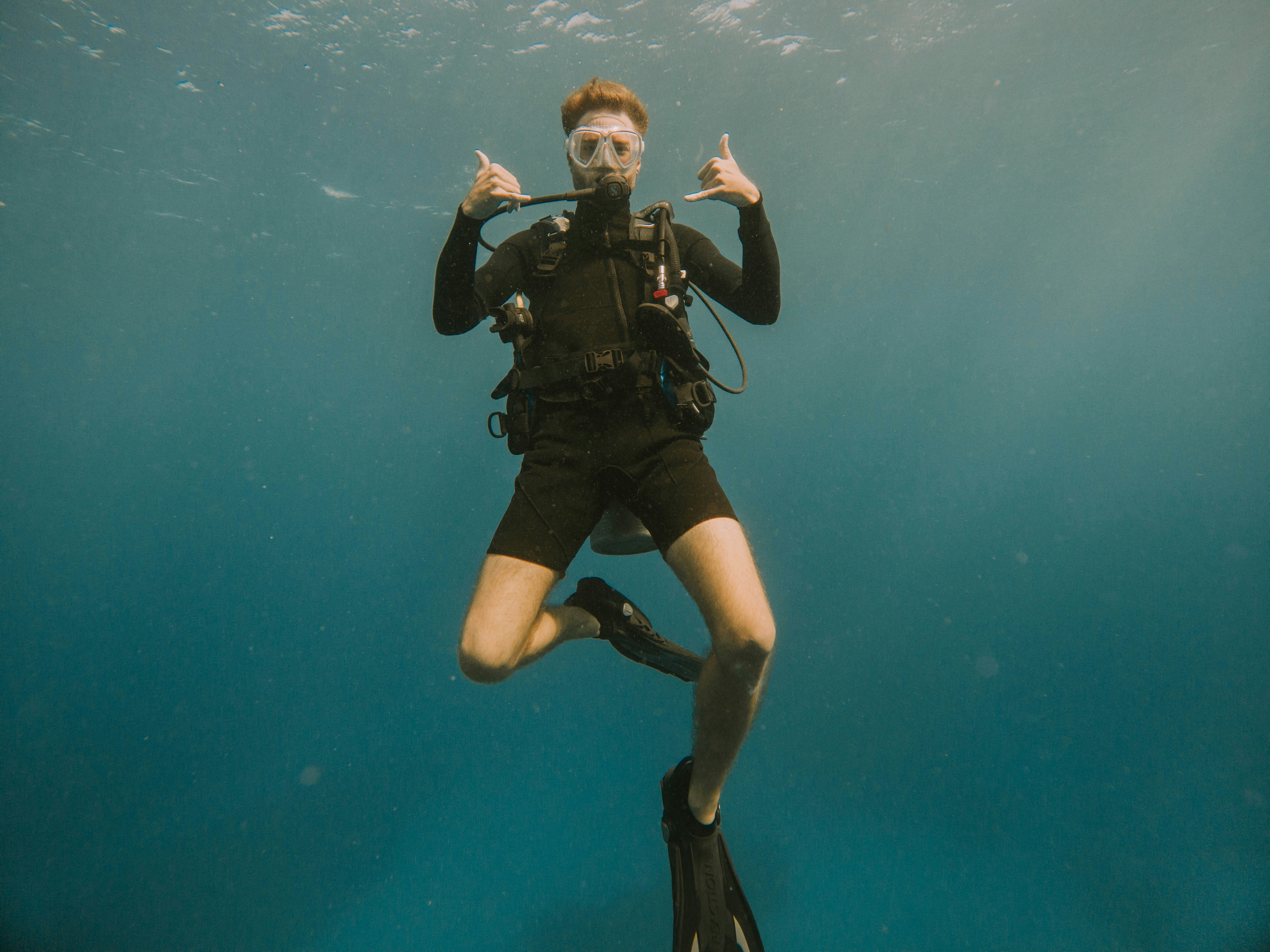 Underwater Diver in Mid-Frame: Hand Signals and Gear in Clear Caribbean Depths