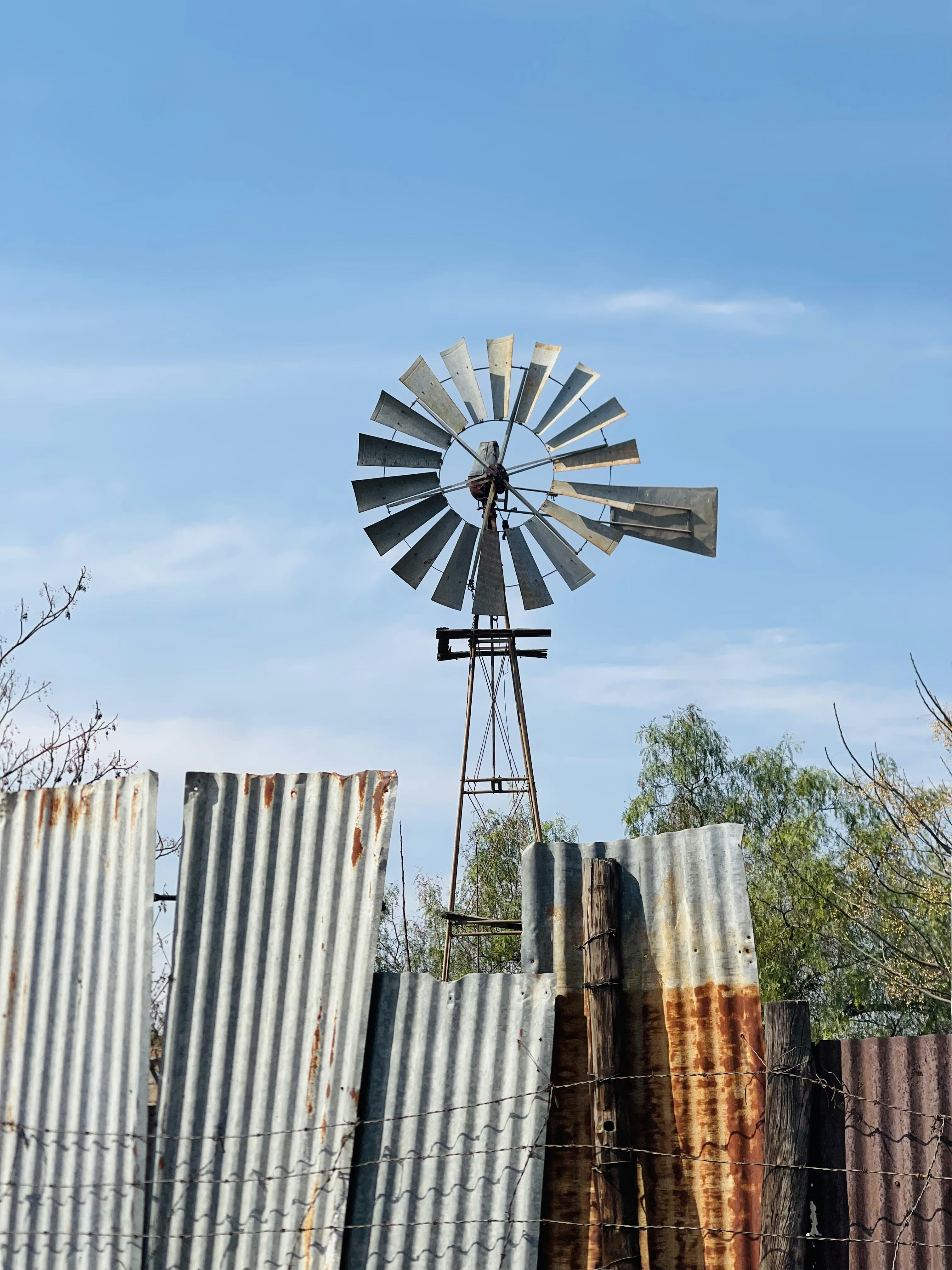 A windmill sitting on top of a metal roof photo – Free Outdoors Image ...