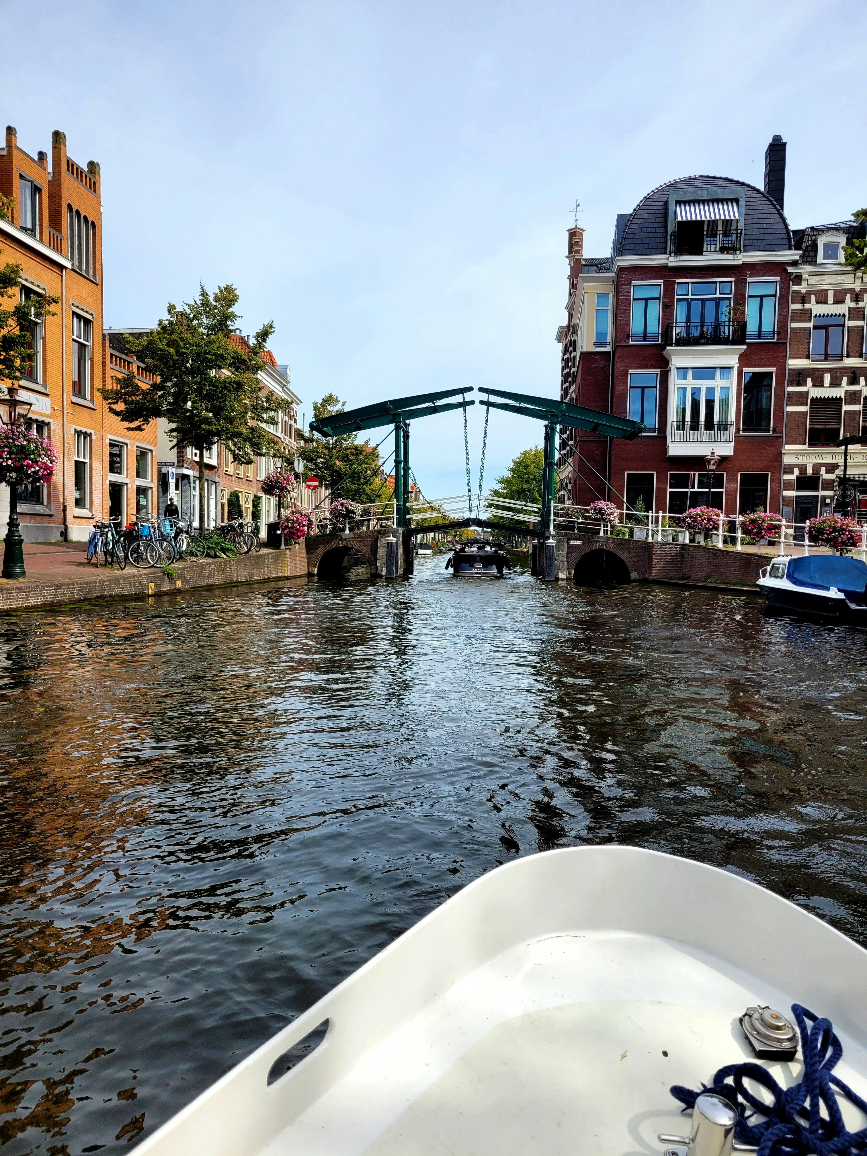 A serene canal scene featuring a charming bridge and colorful buildings lining the waterway, with a boat navigating through the calm waters.