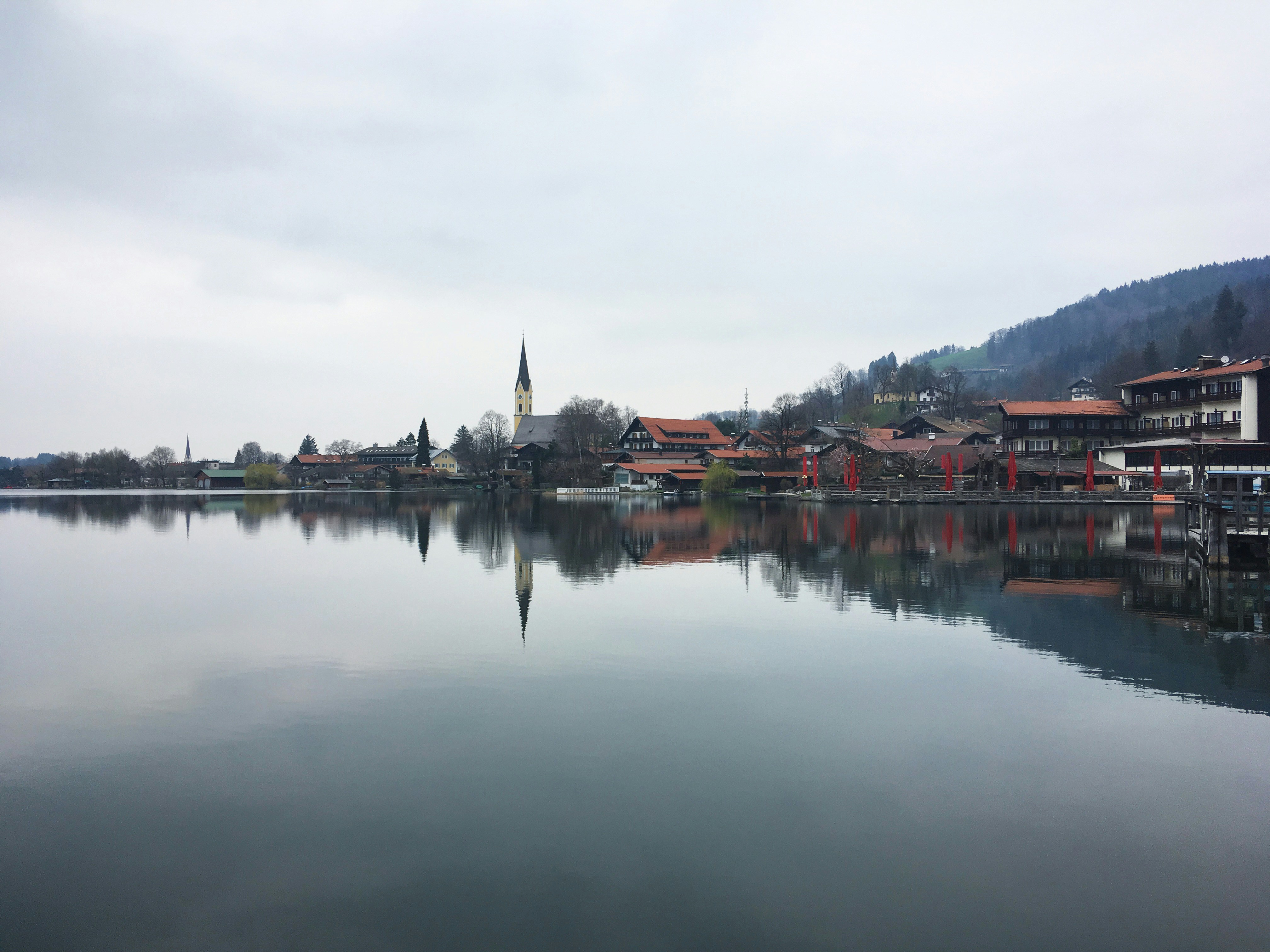 Pastoral Reflections: a calm lakeside village beneath a soft, overcast sky