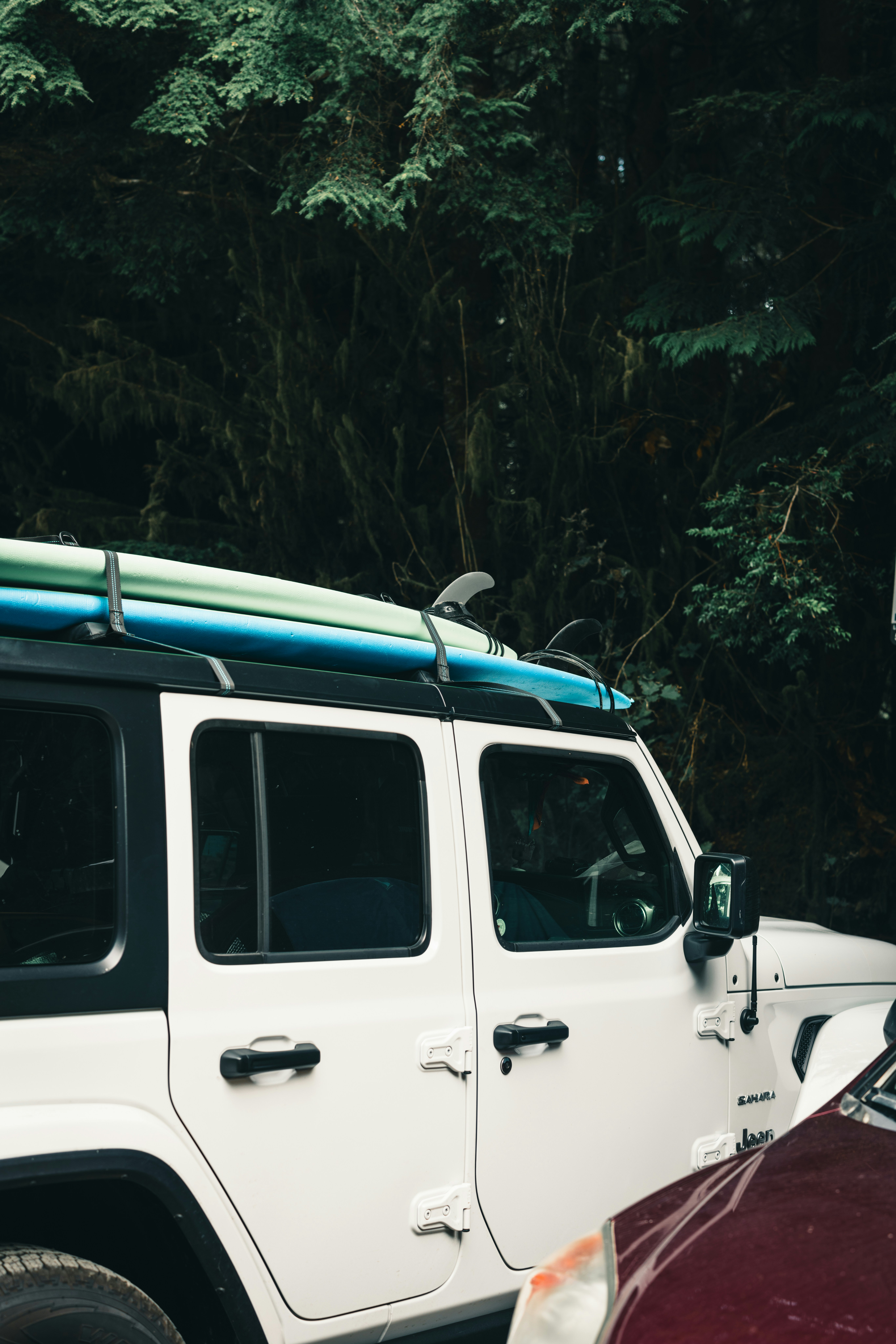 A white jeep with a surfboard on top of it photo – Free Canada Image on ...