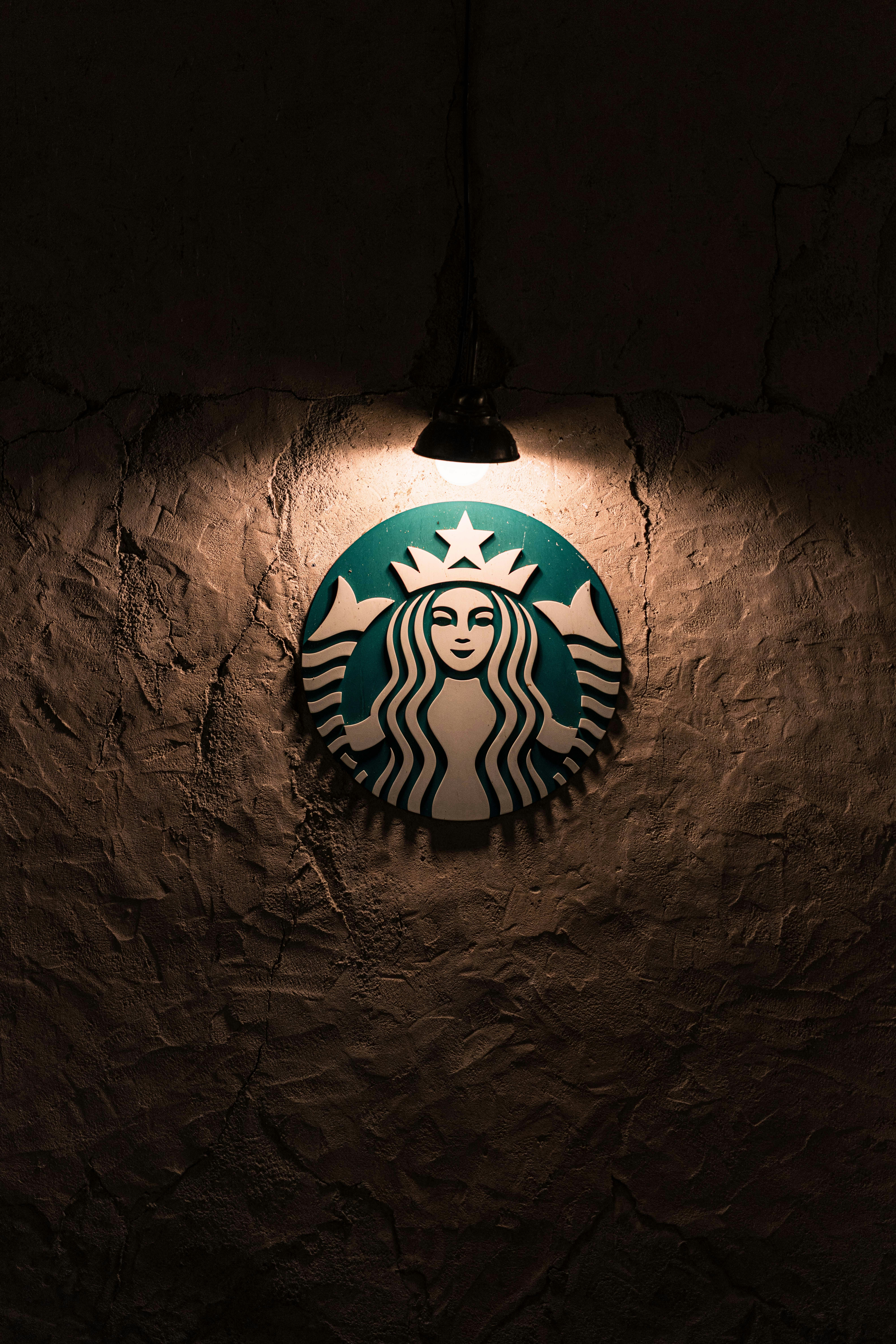 A starbucks sign hanging from the side of a wall photo – Free Dubai ...