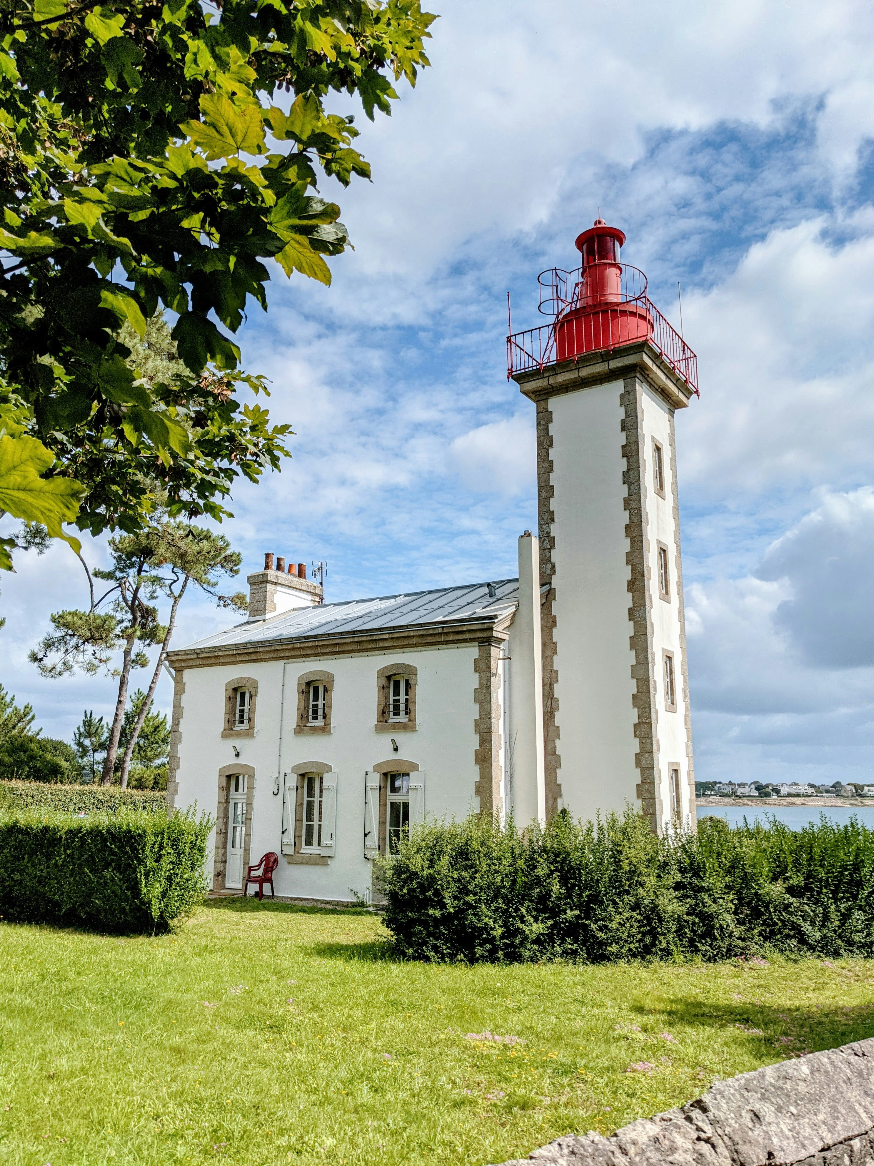 Red-Lantern Beacon Over the Green Coast: Seaside White Cottage and Lighthouse