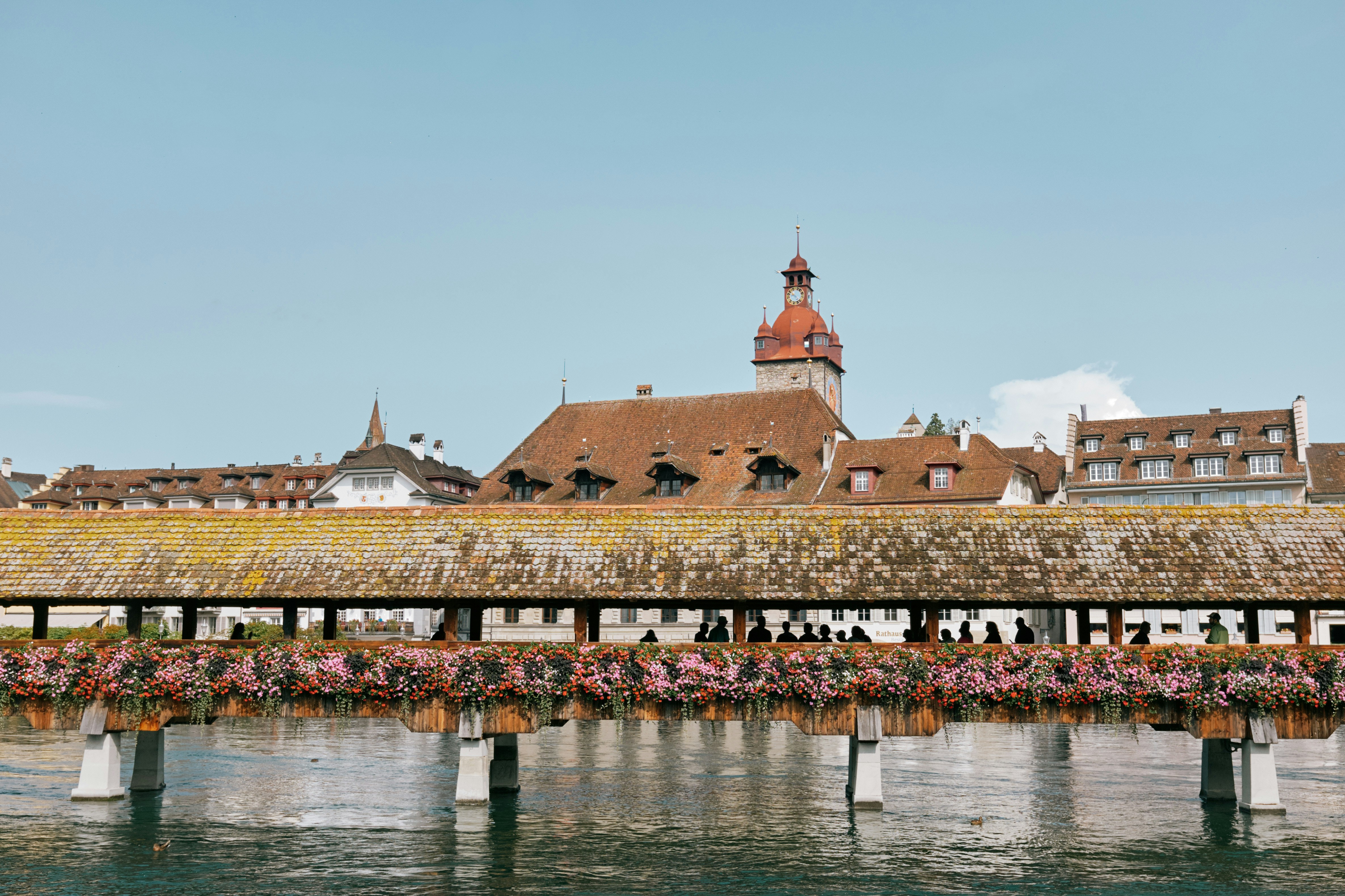 A building with a clock tower on top next to a body of water photo ...