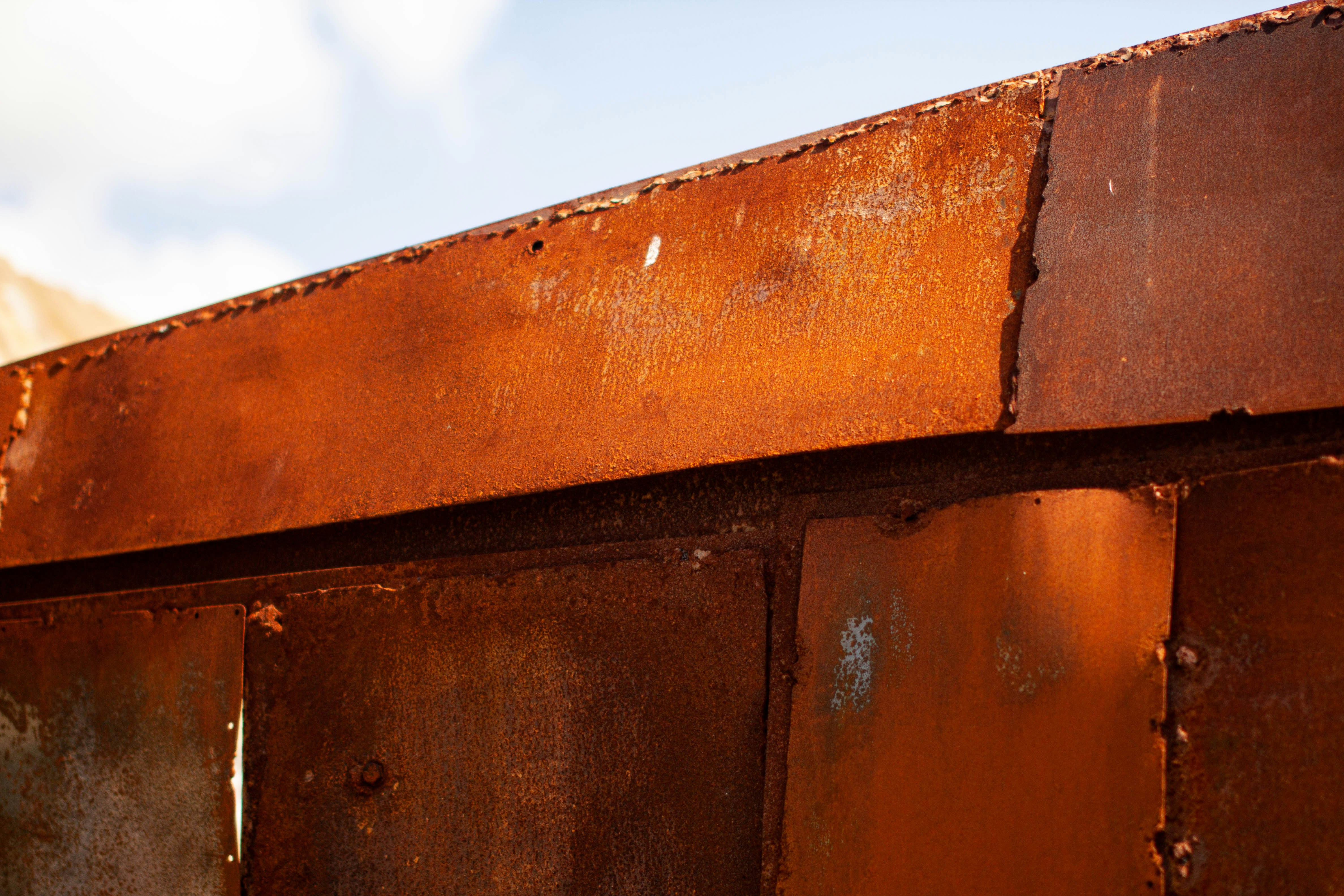 A rusted metal structure with a sky in the background photo – Free ...