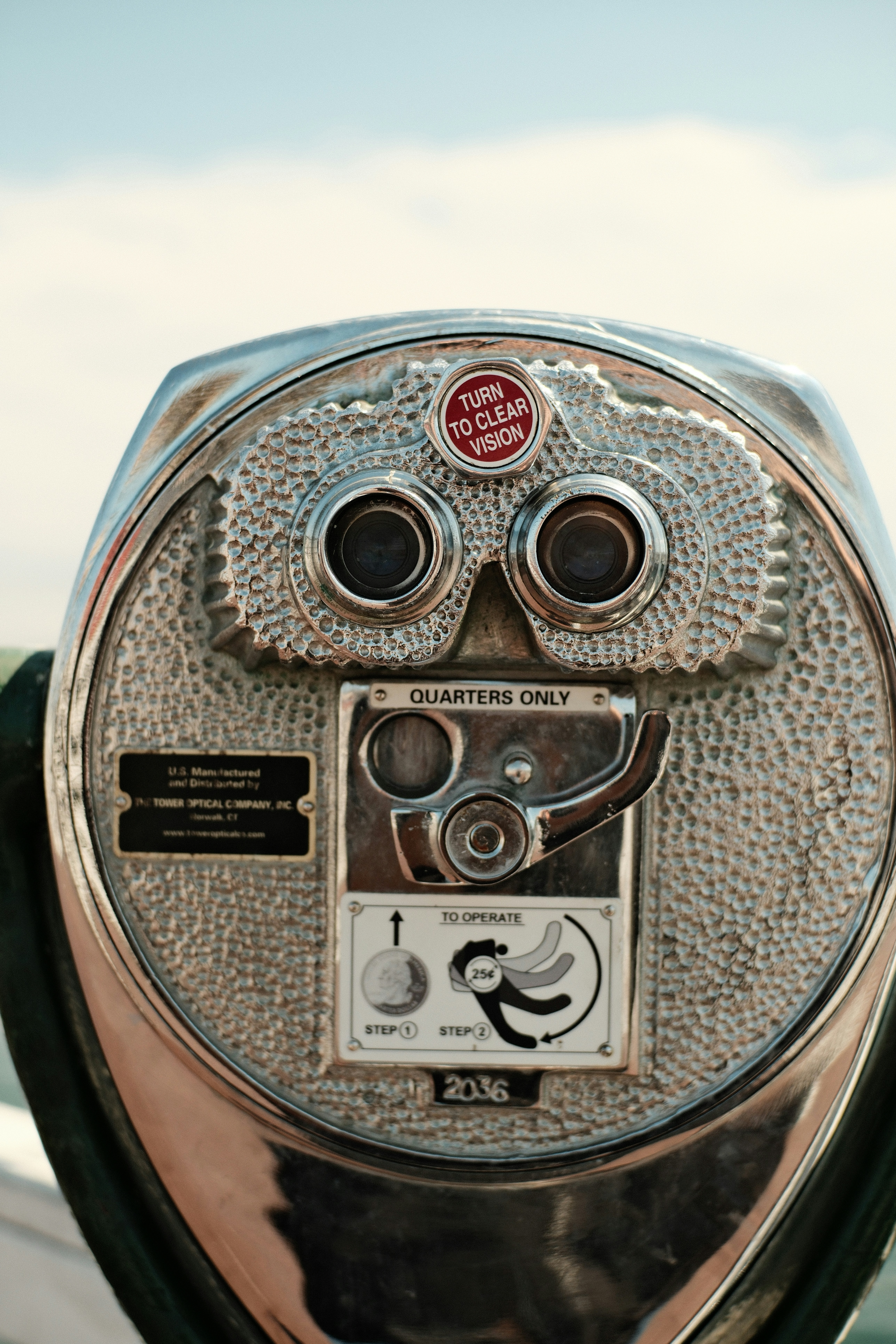 Retro Coin-Op Telescope: a chrome sentinel eyeing the horizon under a pale sky.