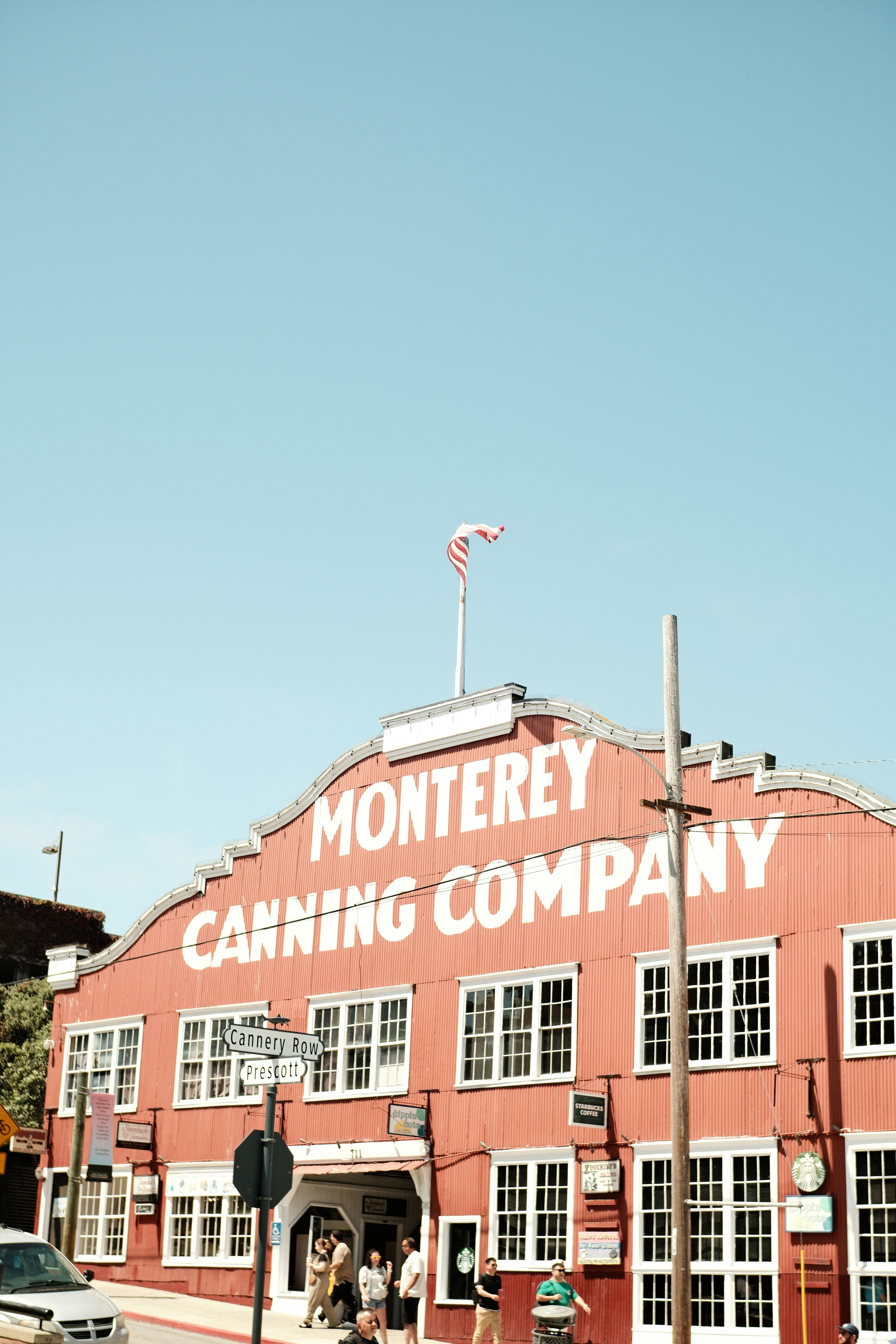Red Facade of Monterey Canning Company Under a Cloudless Sky